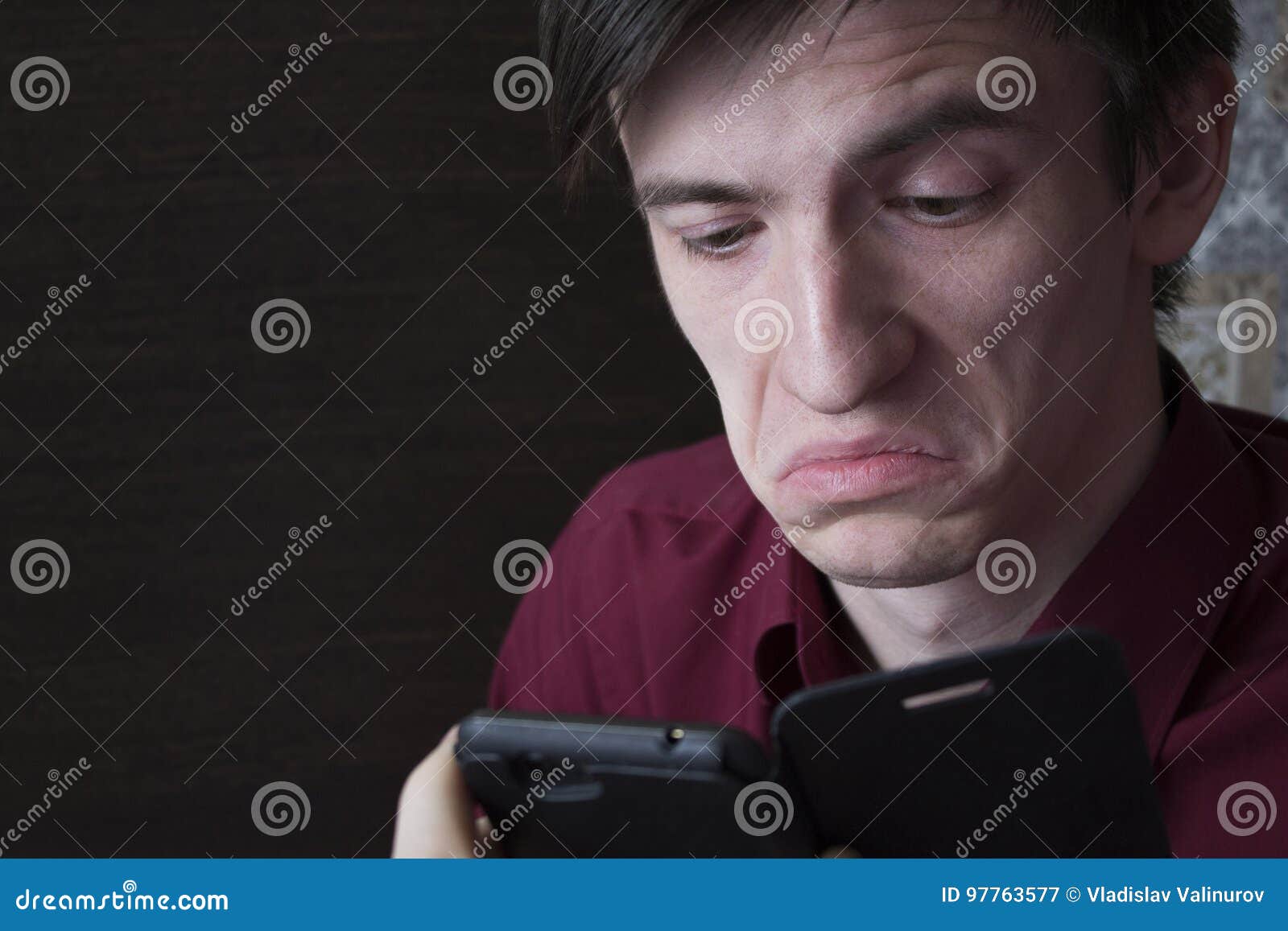Young Guy Looking into Smartphone, Sad Face Stock Image - Image of ...