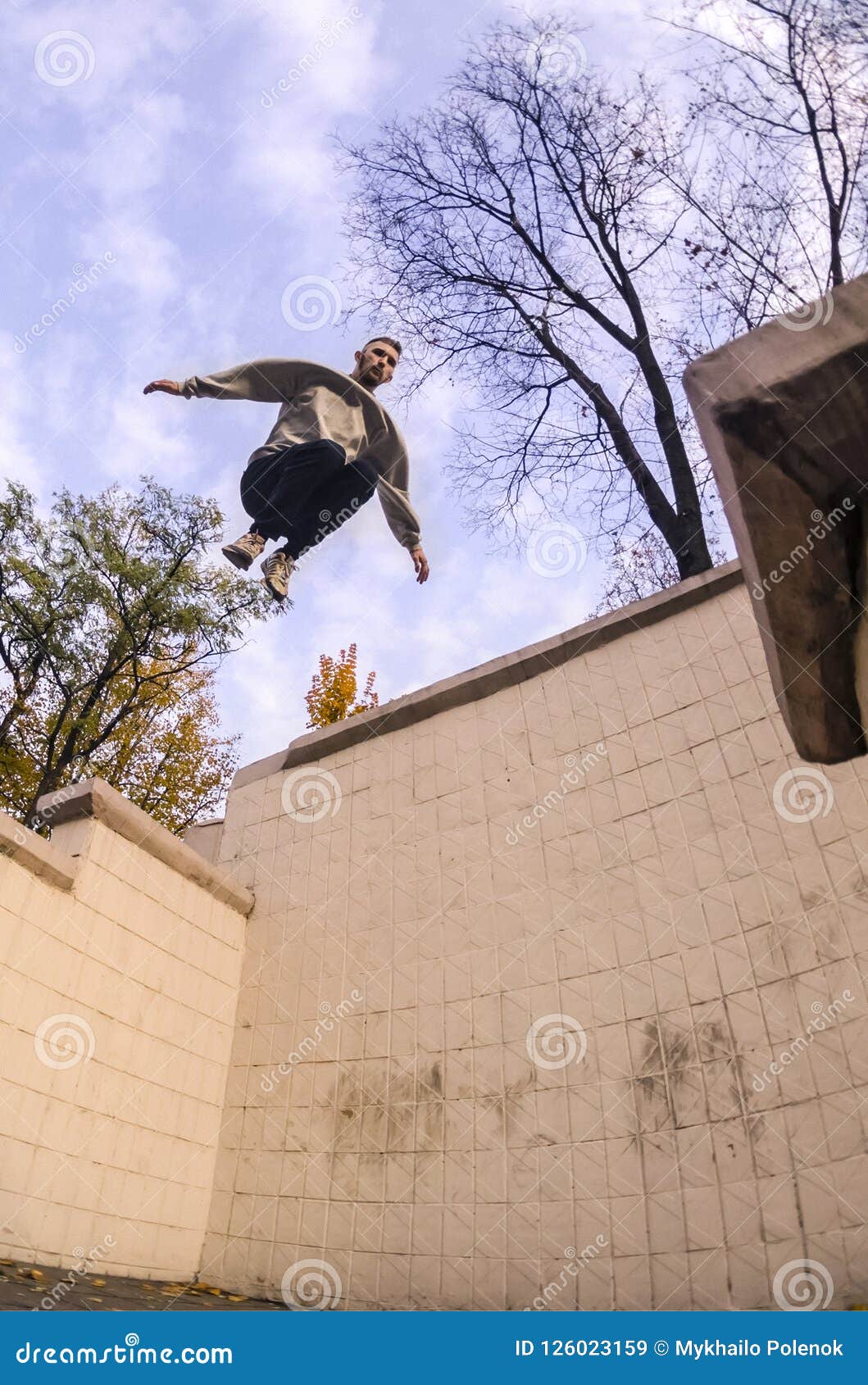 A Young Guy Performs a Jump through the Space between the Concrete ...