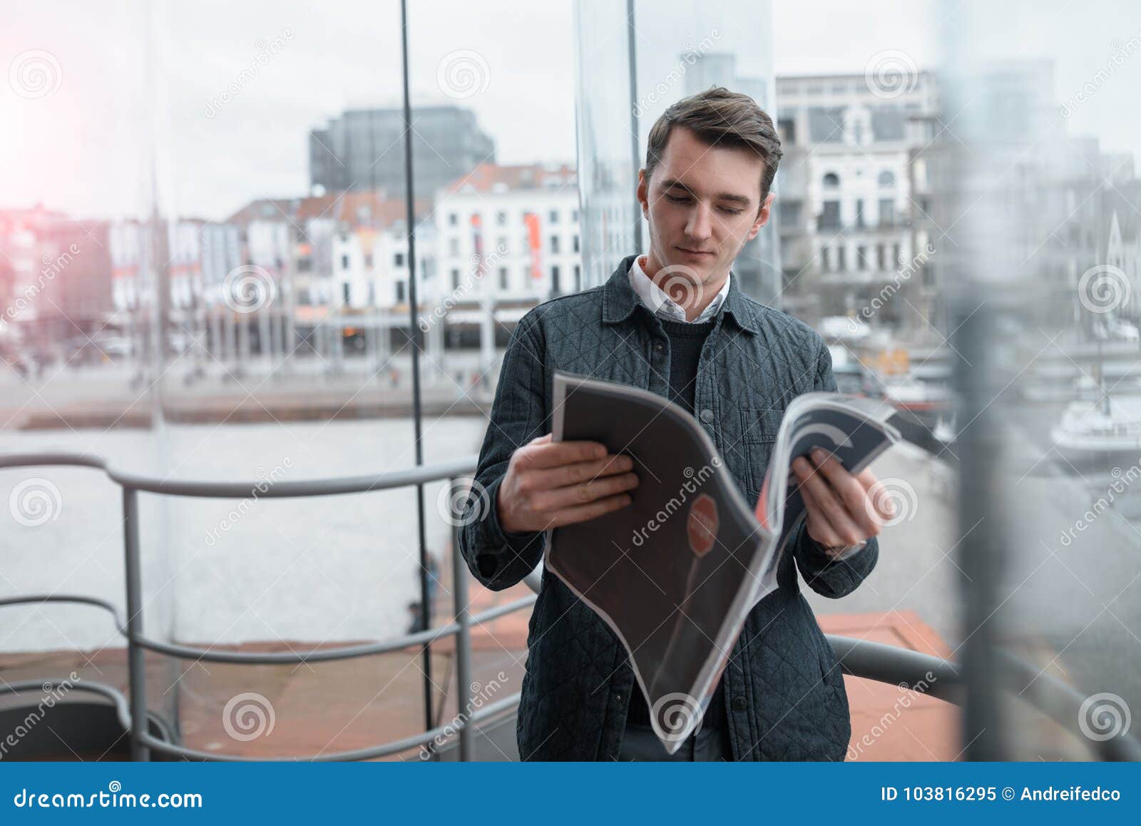 A Young Guy Reads a Newspaper Inside. Stock Image - Image of lying ...