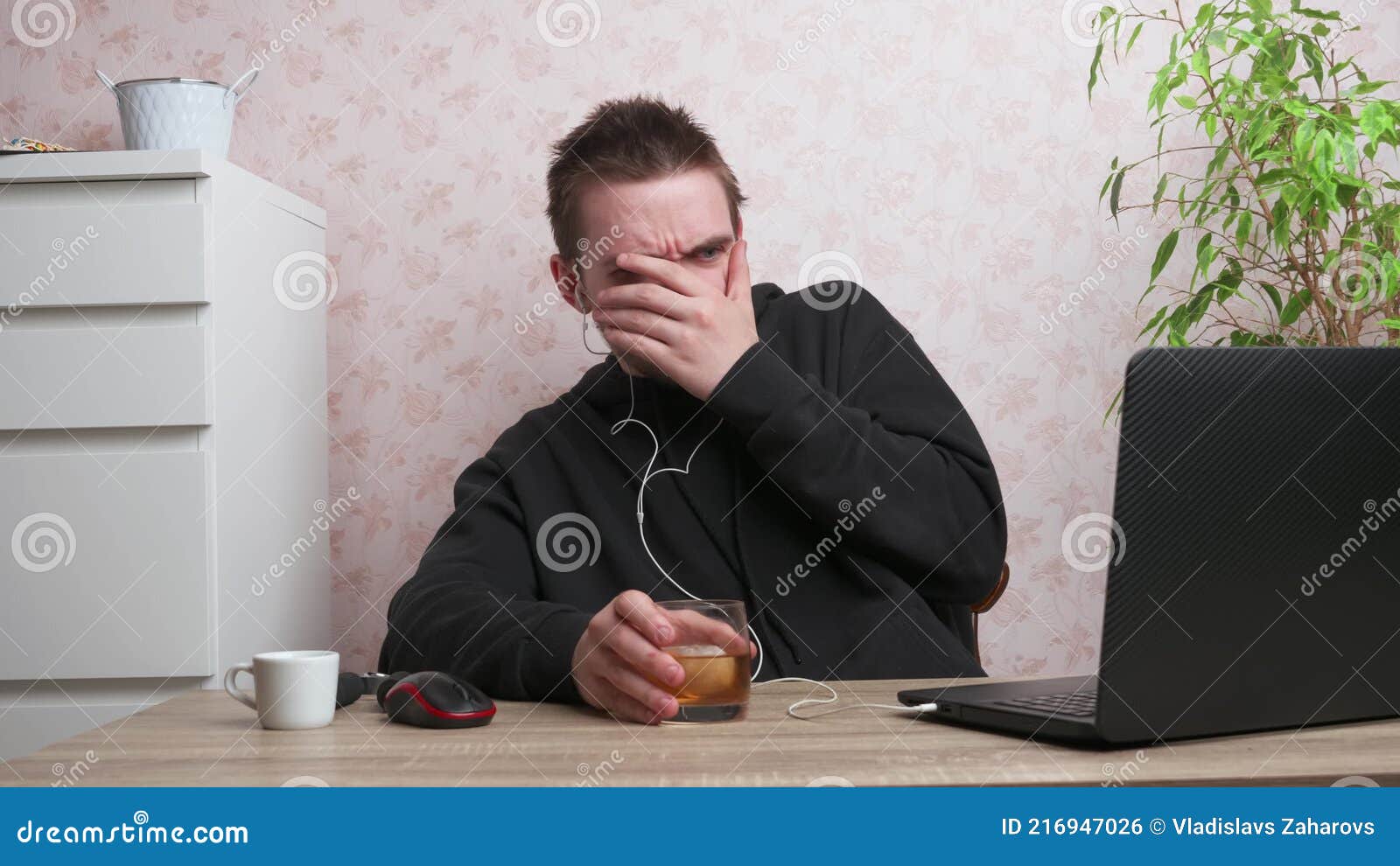 Young Guy Sitting at a Computer Watching a Scary Movie, Sitting at a ...