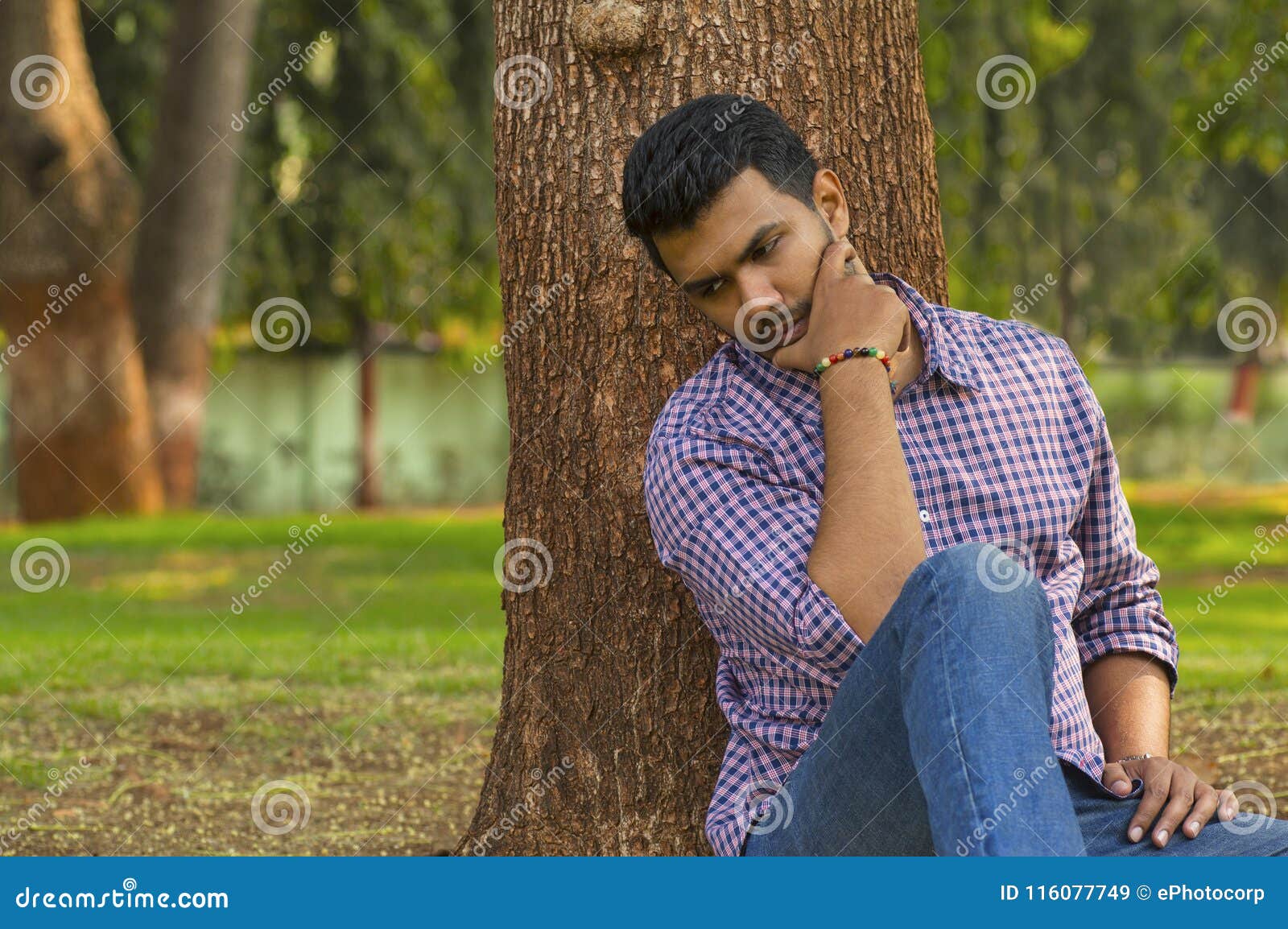 Young Guy Sitting and Thinking Leaning Against Tree Stock Image - Image ...