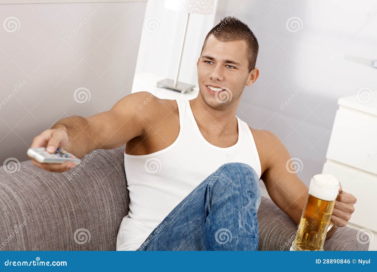 Young Guy on Sofa with Beer and Remote Control Stock Photo - Image of ...