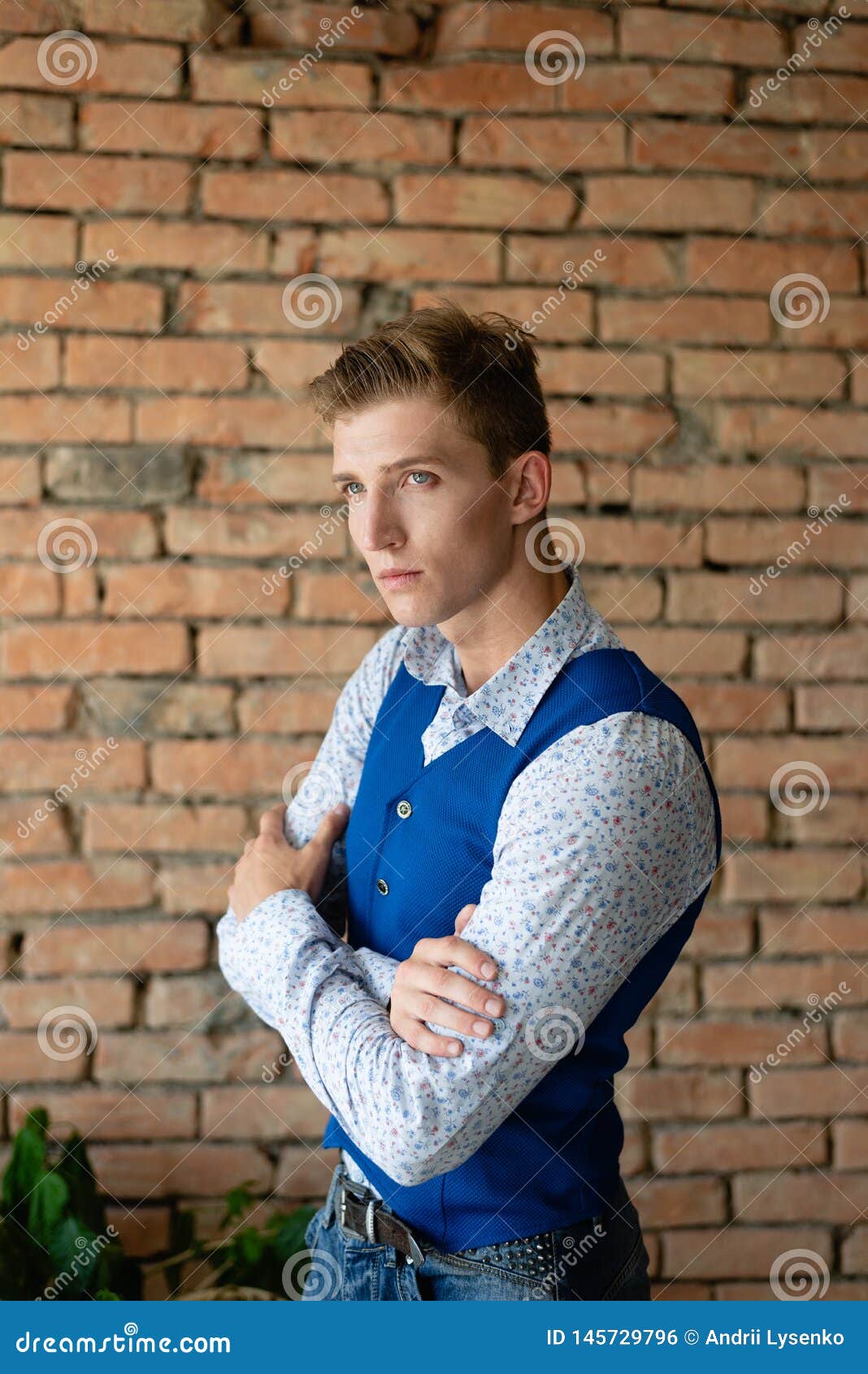 A Young Guy Stands Against a Brick Wall and Looks Forward Thoughtfully ...