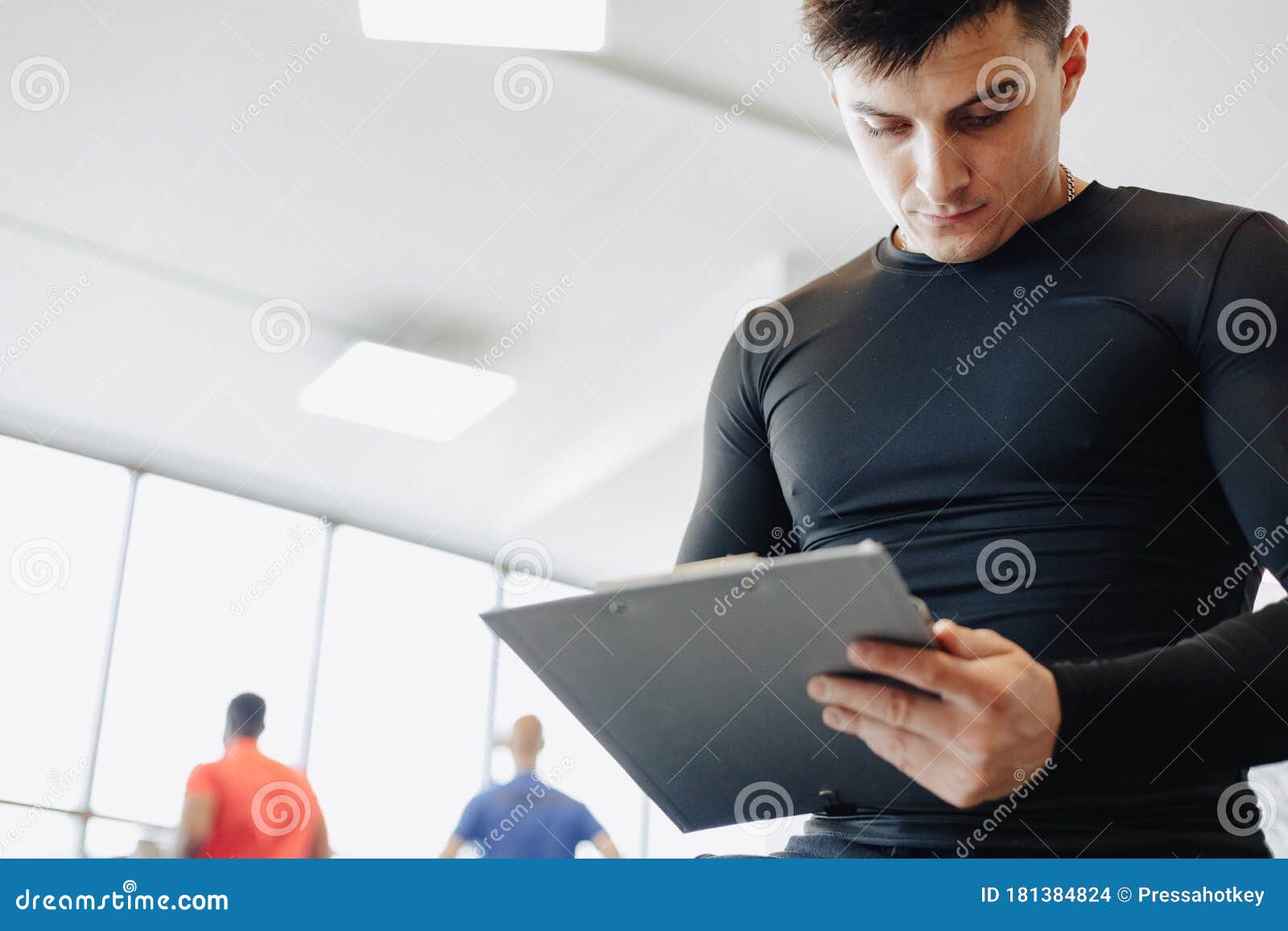 Young Guy Trainer Takes Notes in the Gym. Personal Trainer for Sports ...