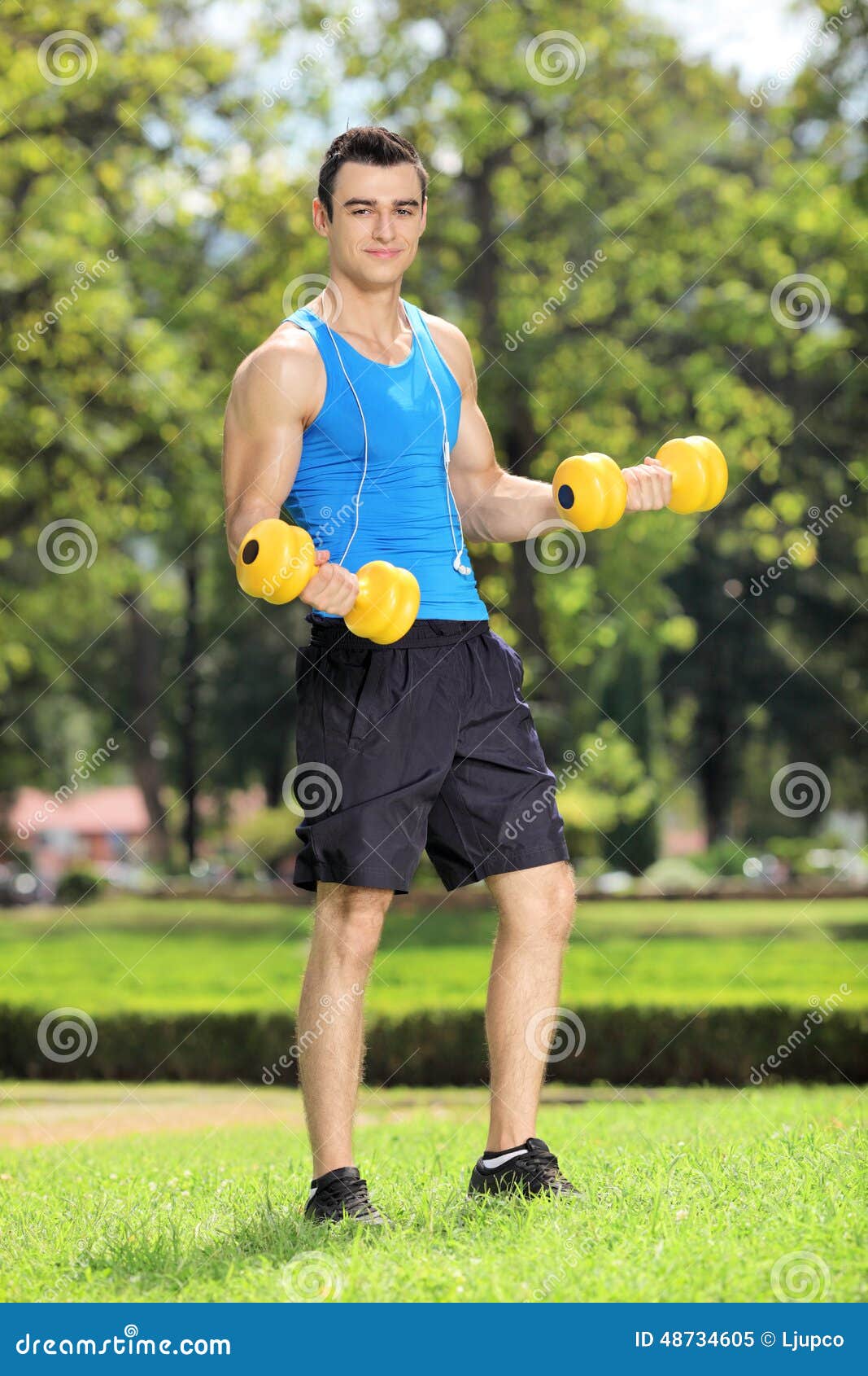 Young Guy Training with Two Dumbbells in a Park Stock Image - Image of ...