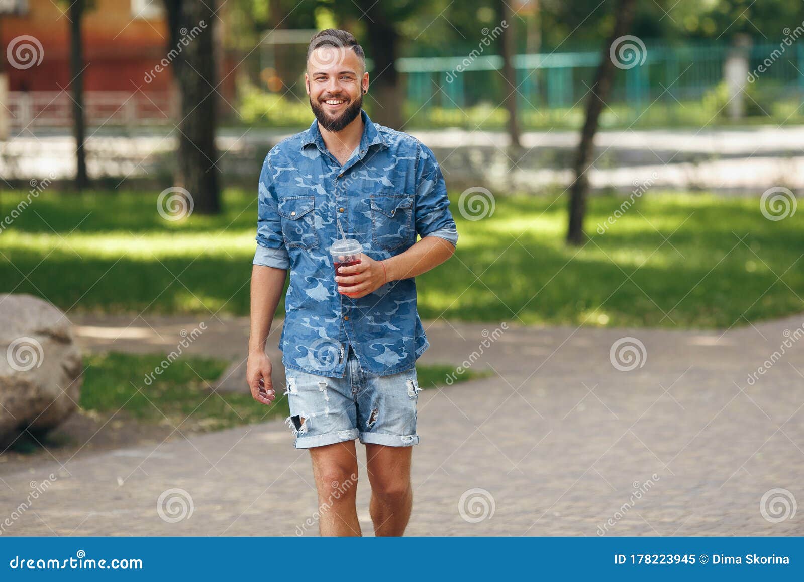 A Young Guy Walking in the Park with Lemonade in the Spring. Spring Day ...