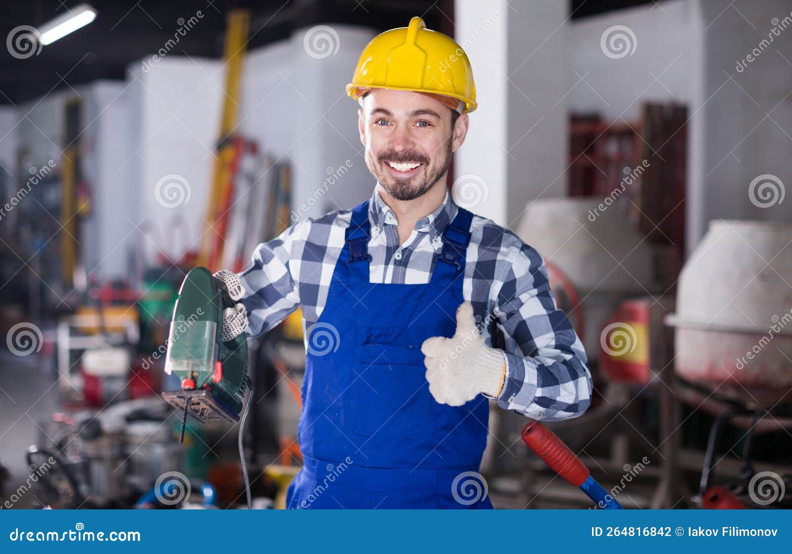 Young Guy Worker is Using Power Jigsaw for Construction Work Stock ...