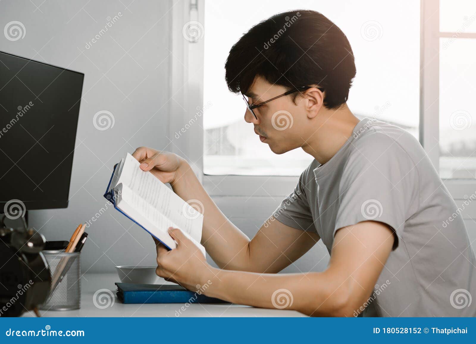 Young Handsome Asian Man Reading Book at Work Desk in Free Time from ...