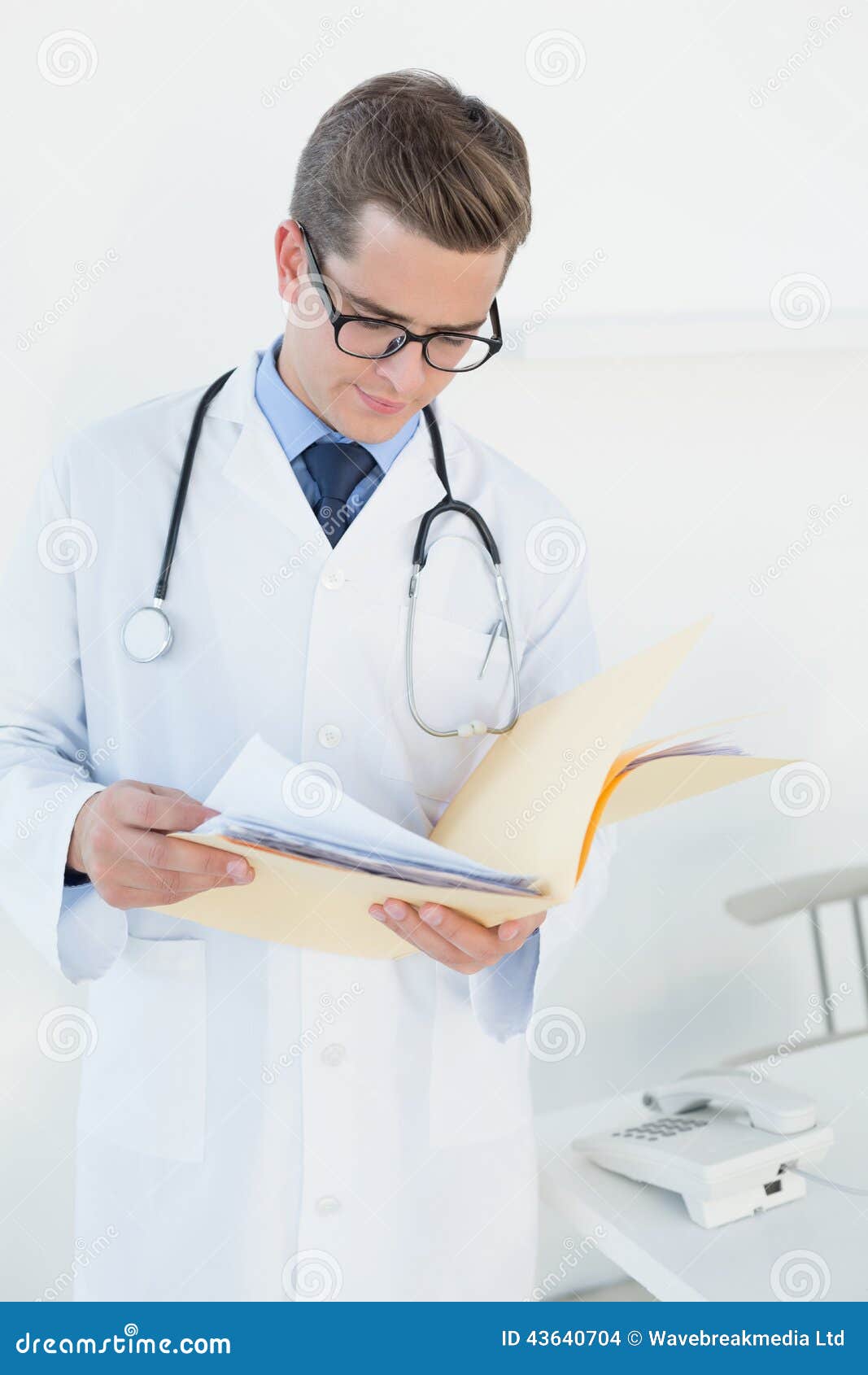 Young Handsome Doctor Reading File Stock Photo - Image of workplace ...