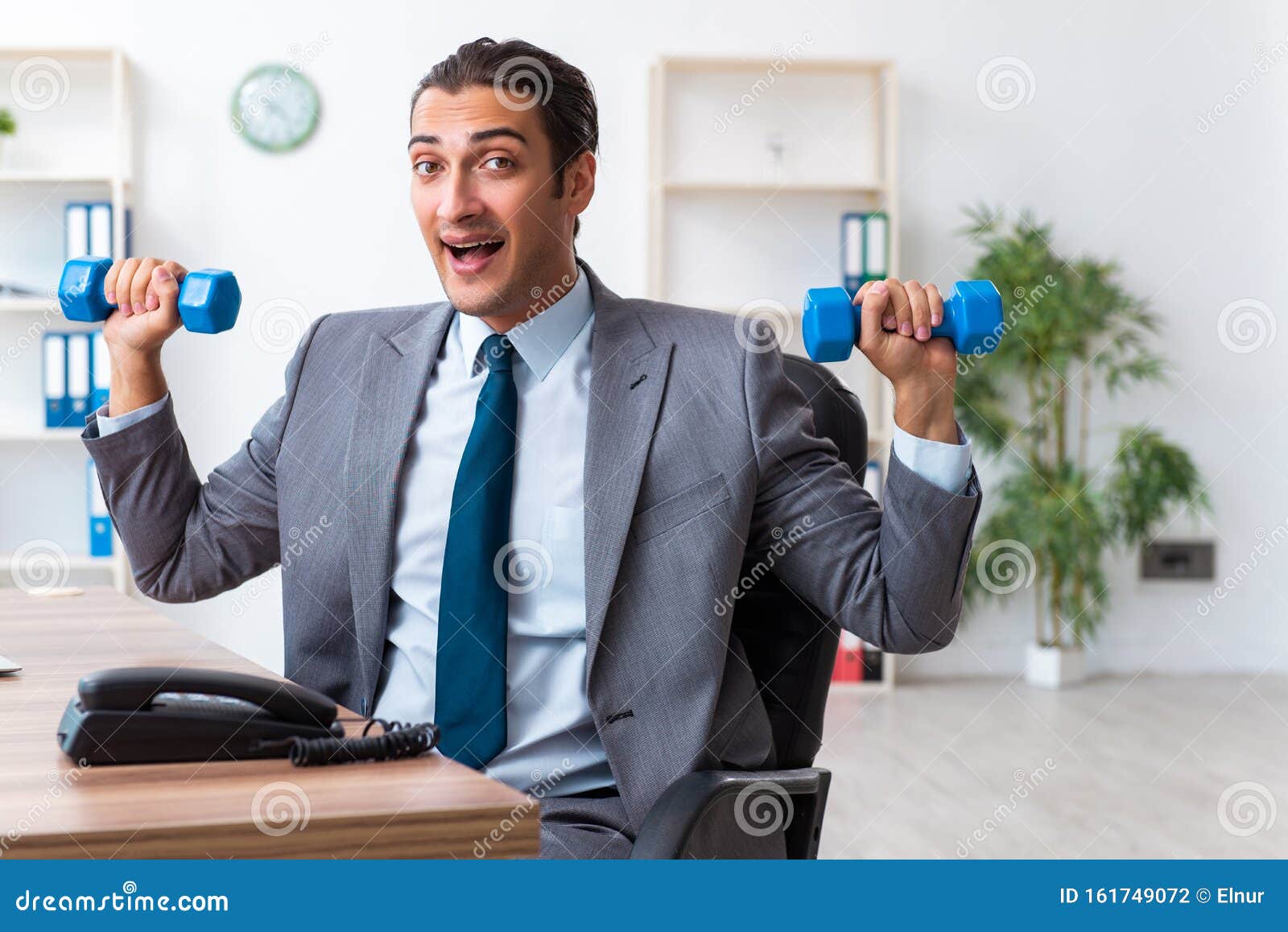Young Handsome Employee Doing Sport Exercises at Workplace Stock Photo ...