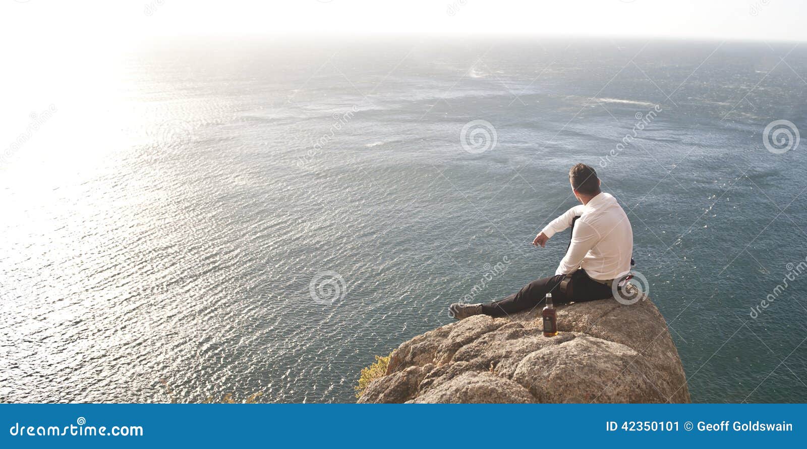Young Handsome Guy Sitting on Rock Above Ocean Stock Image - Image of ...