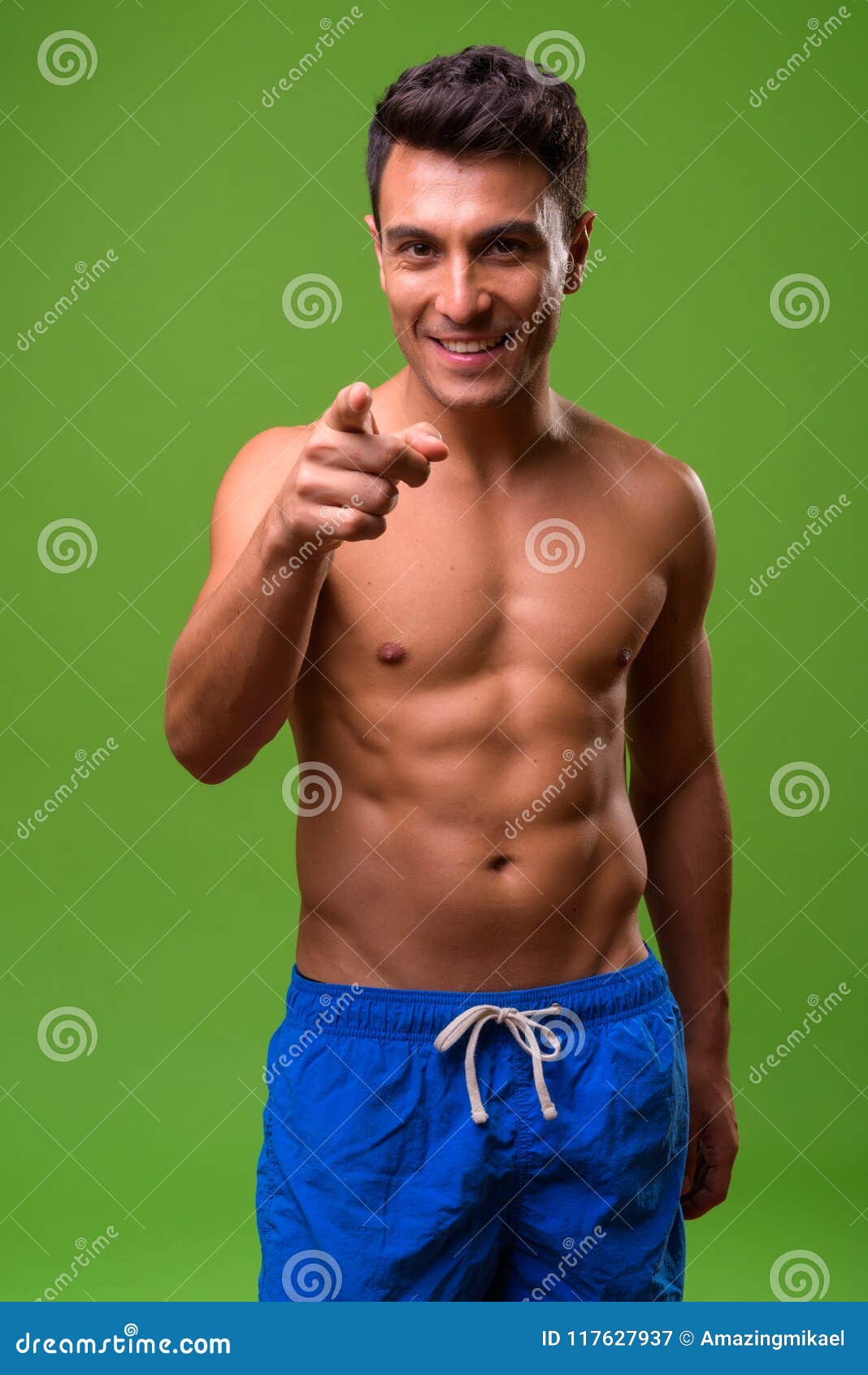 Young Handsome Hispanic Man Shirtless Against Green Background Stock