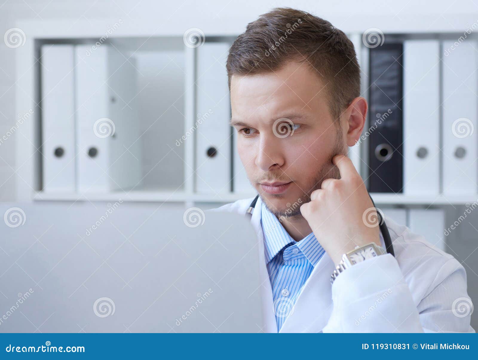 Young Handsome Male Doctor Using Computer on Desk in Clinic. Stock ...