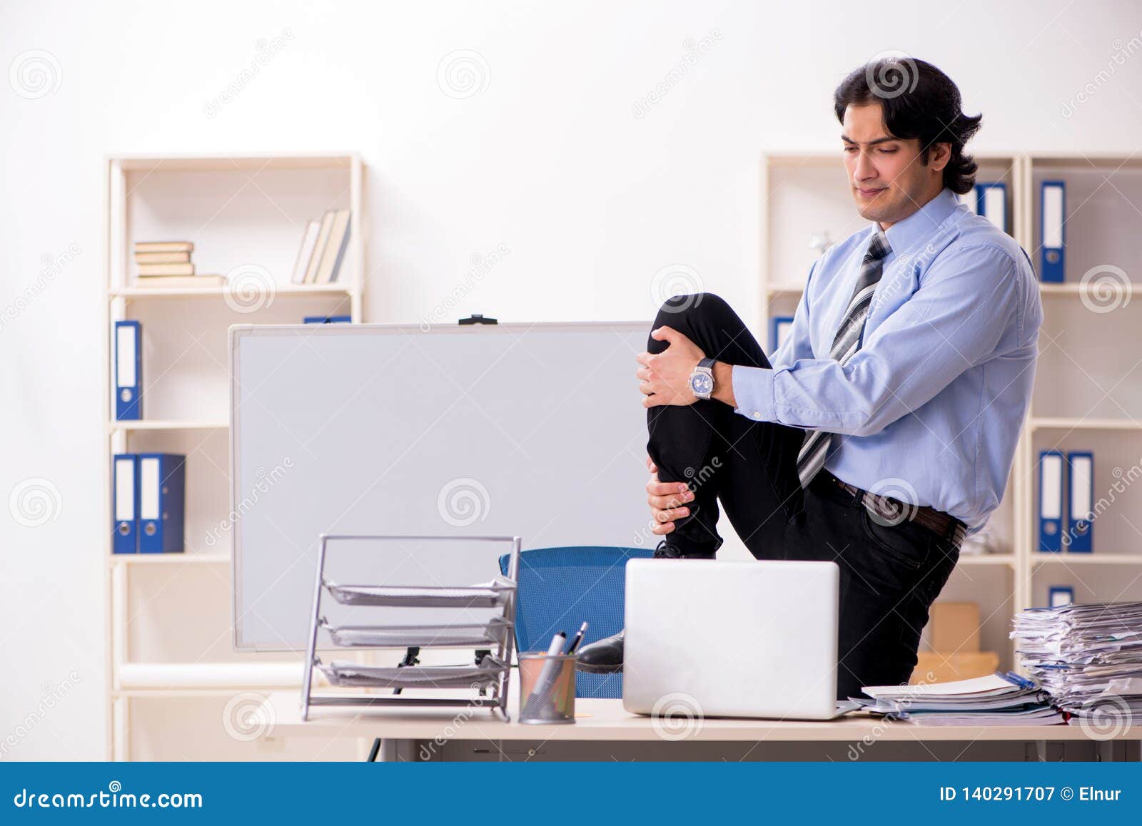 The Young Handsome Male Employee Doing Exercises in the Office Stock ...