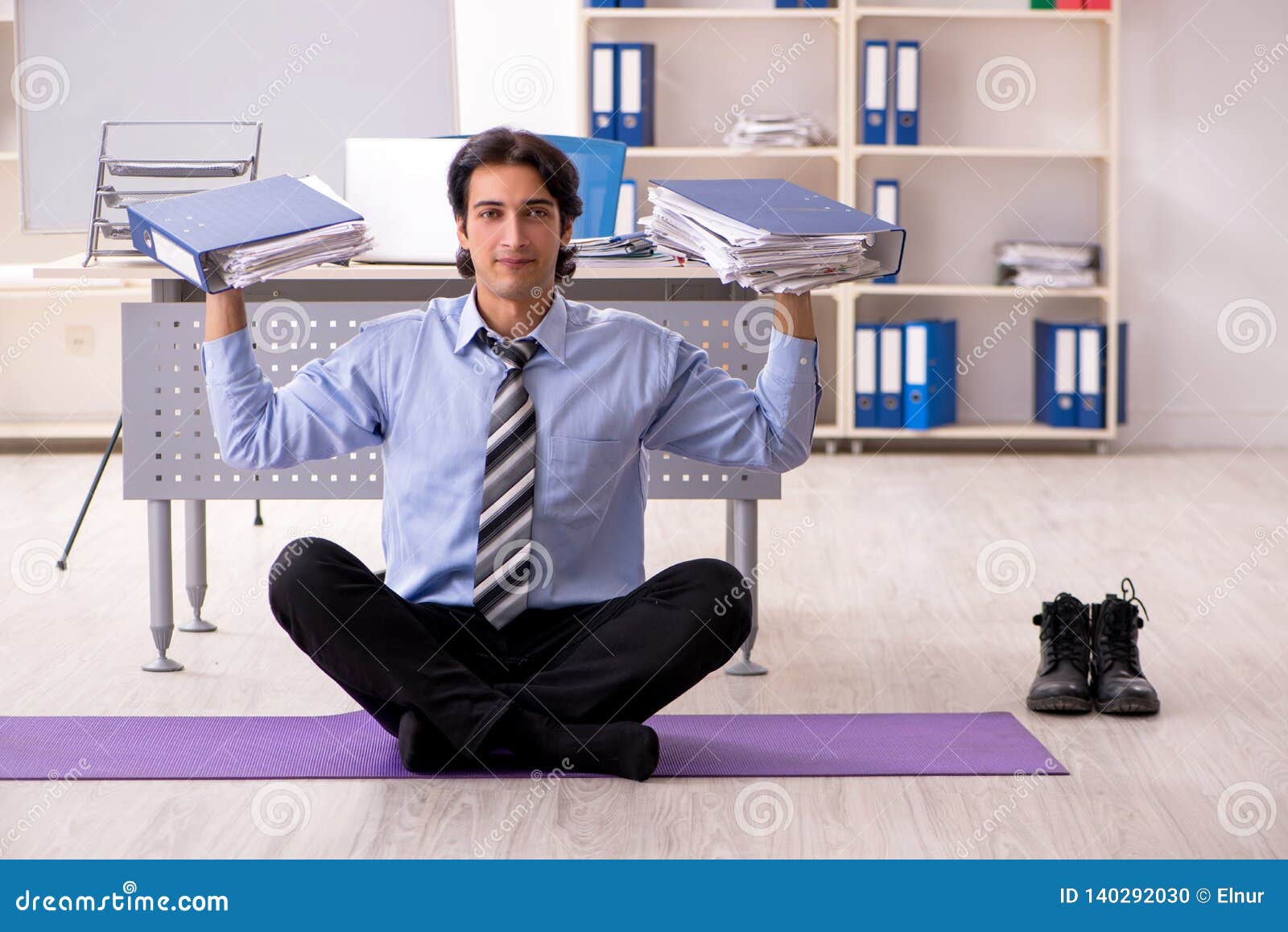 The Young Handsome Male Employee Doing Exercises in the Office Stock ...