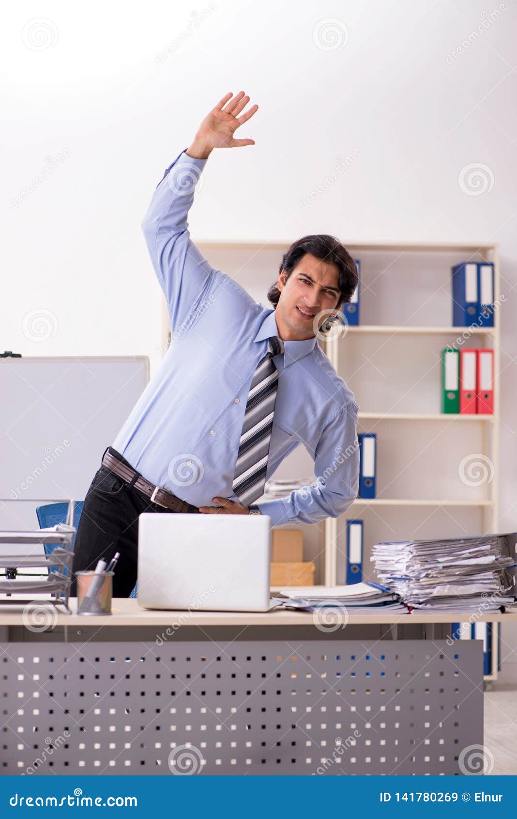 The Young Handsome Male Employee Doing Exercises in the Office Stock ...