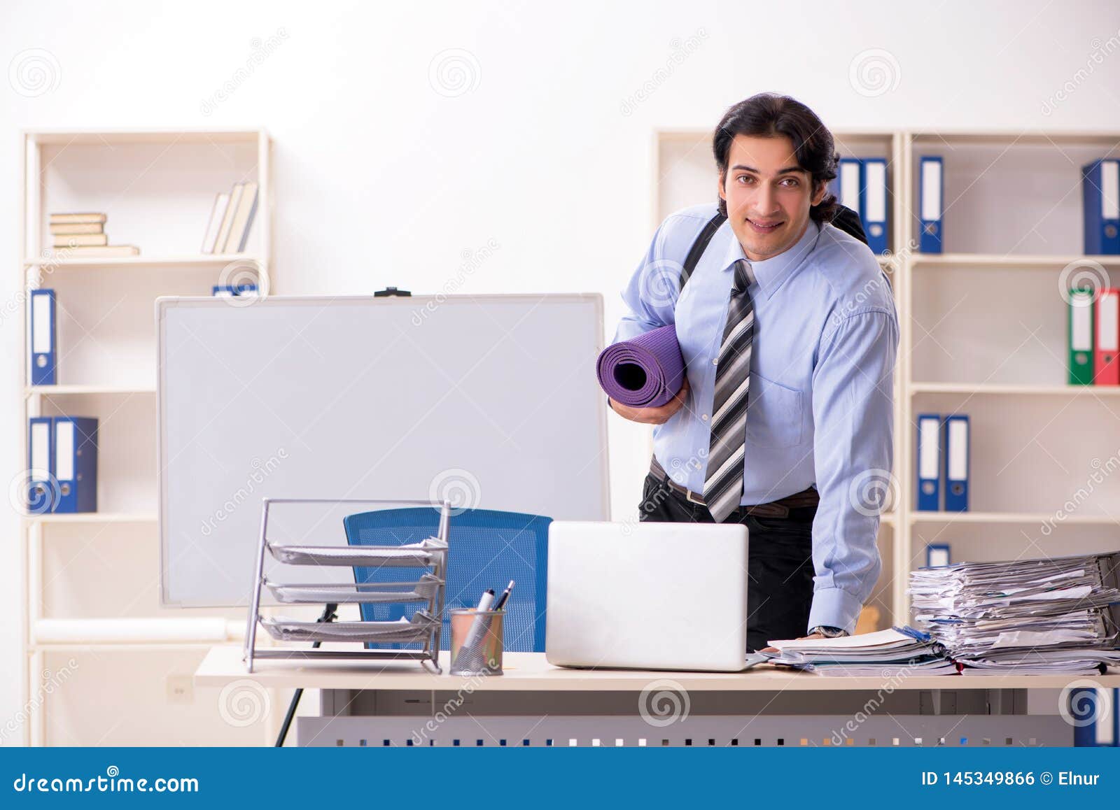 The Young Handsome Male Employee Doing Exercises in the Office Stock ...