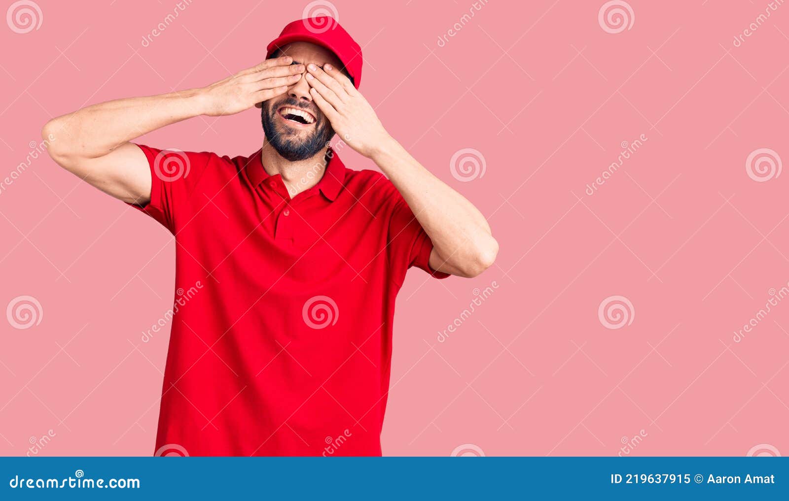Young Handsome Man With Beard Wearing Delivery Uniform Covering Eyes