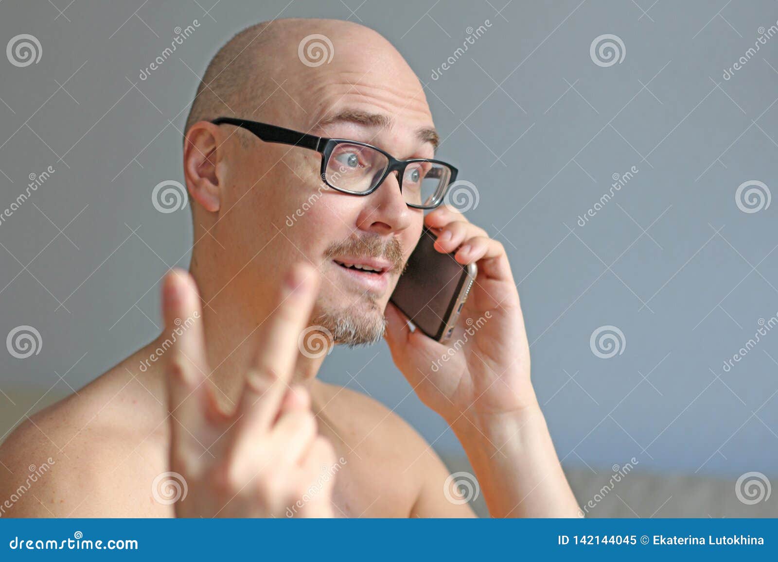 Young Handsome Man In Black Glasses Is Talking On The Phone Closeup