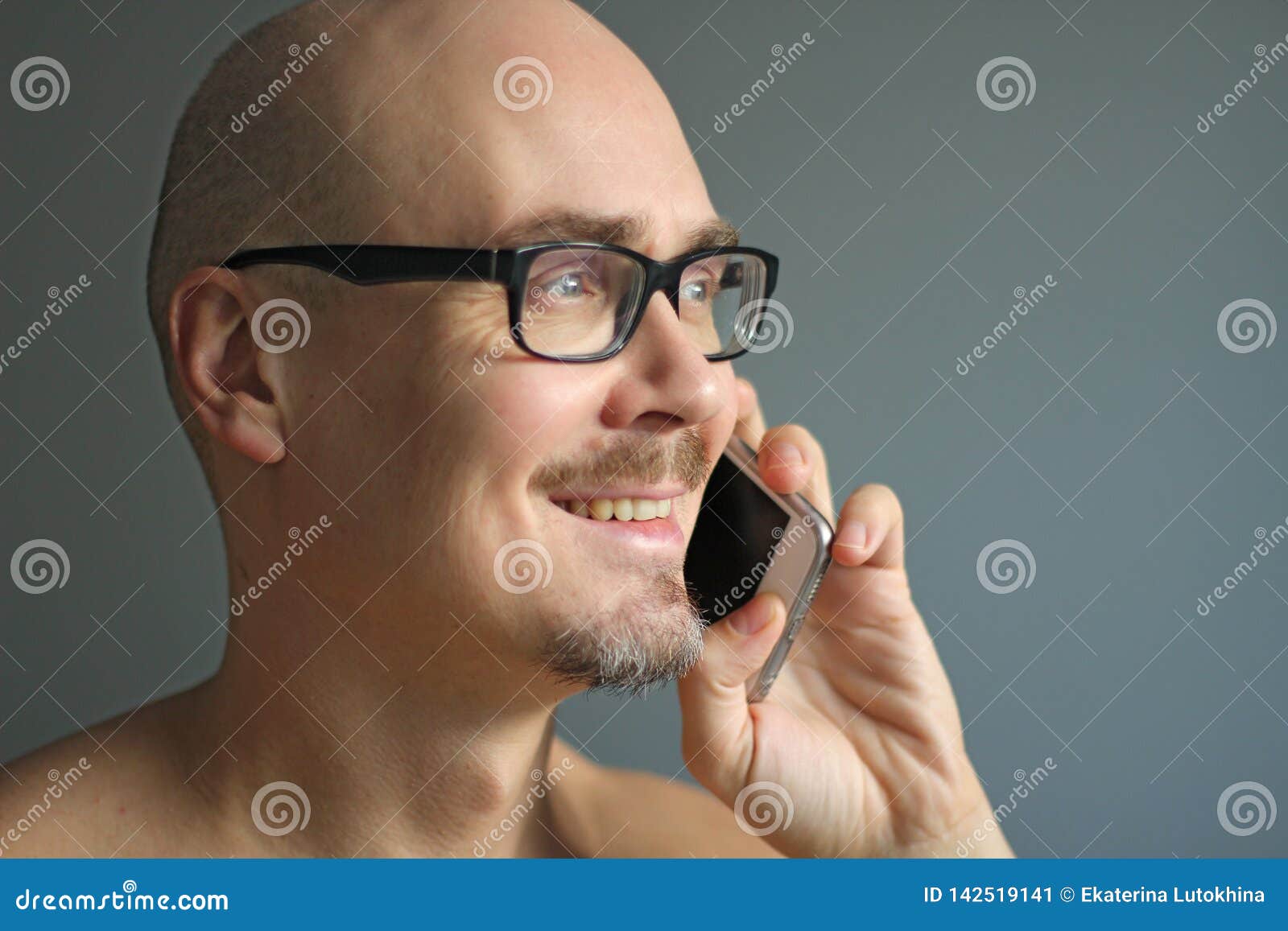 Young Handsome Man In Black Glasses Is Talking On The Phone Smiling