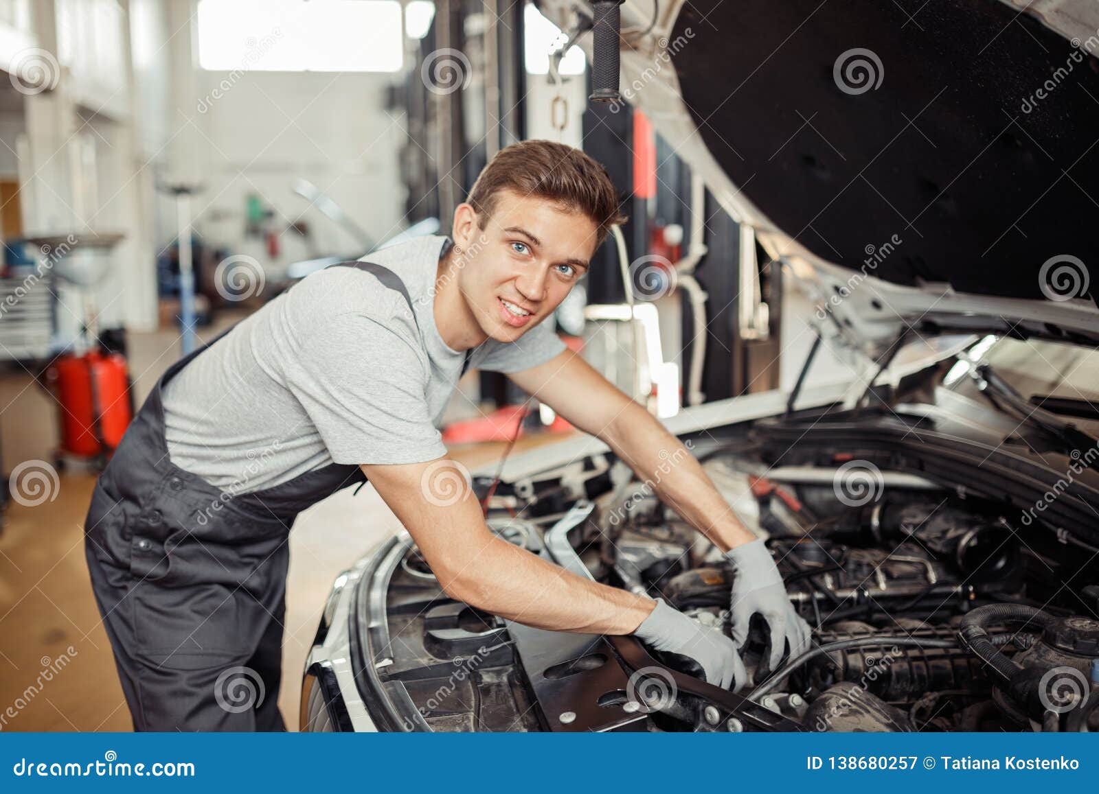 A Young Handsome Man is Checking the Engine of a Car at a Car Service ...