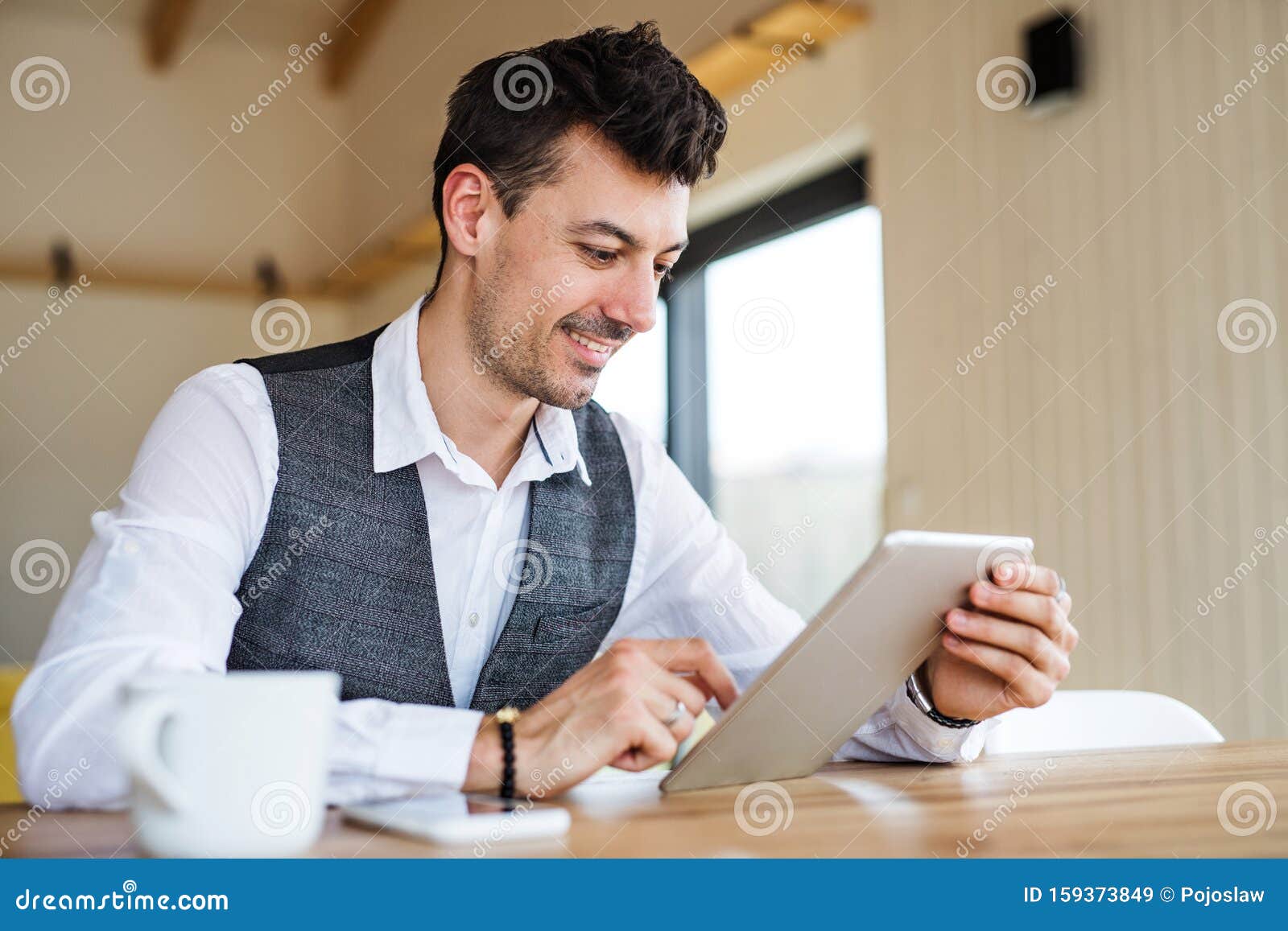 Young Man with Coffee Sitting at the Table, Using Tablet. Stock Image ...