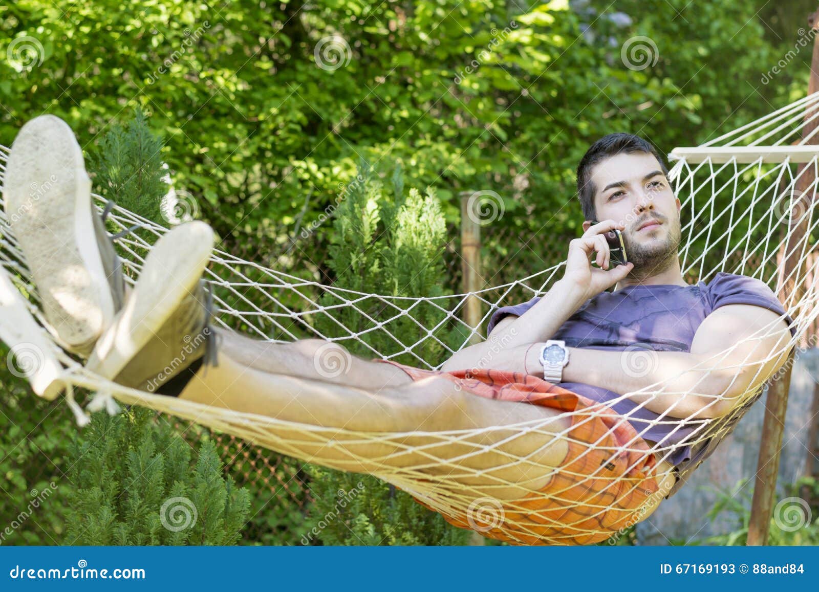 Young Handsome Man Laying in a Hammock and Talking on the Phone Stock ...