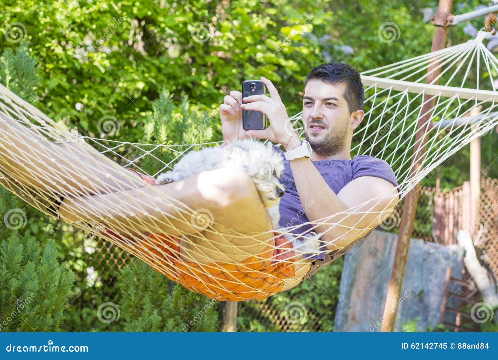 Young Handsome Man Relaxing in Hammock and Playing with His Phone Stock ...
