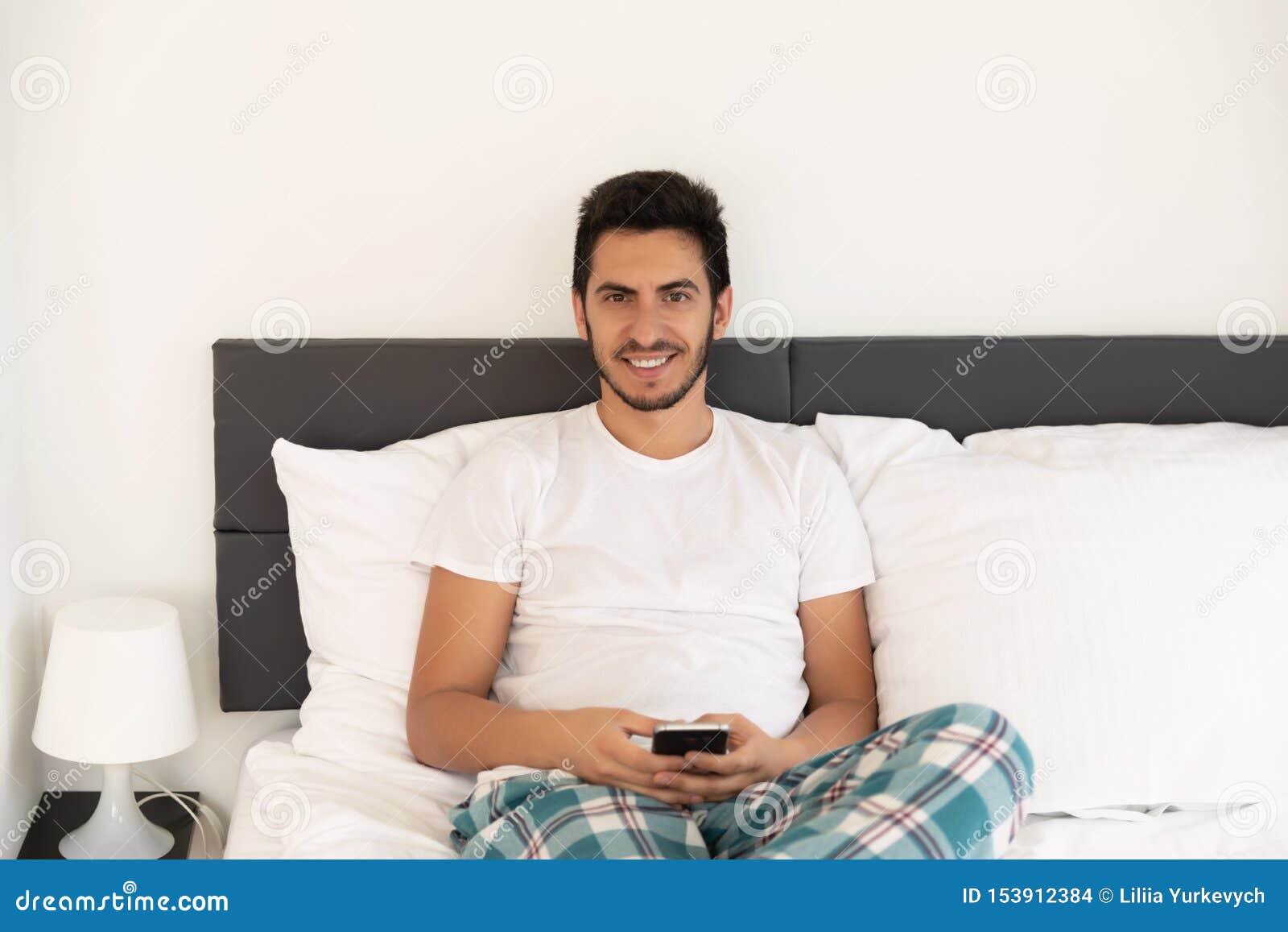 Young Handsome Man Sitting on the Bed. Stock Photo - Image of indoors ...
