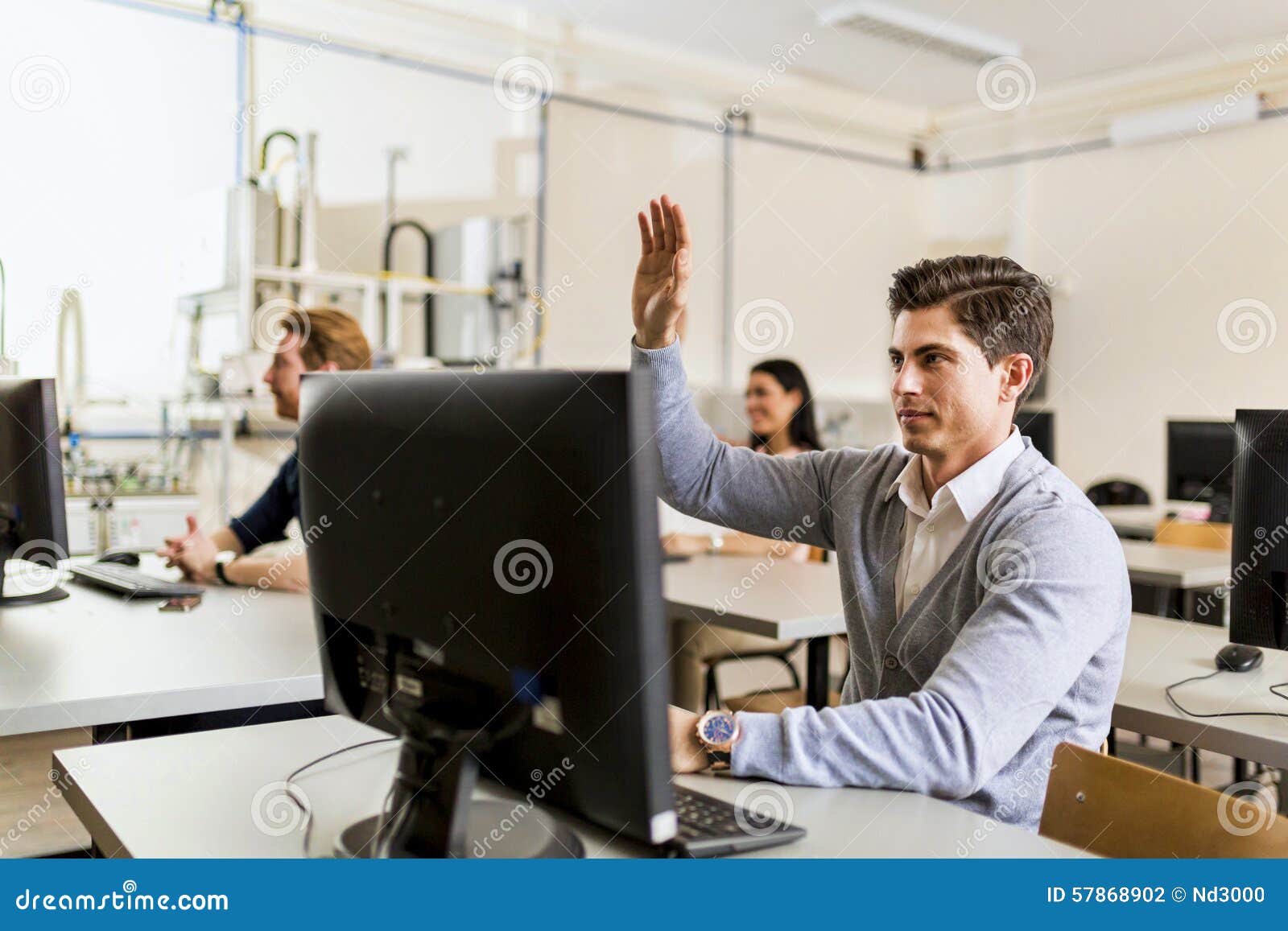 Young Handsome Man Sitting in Front of a Computer Raising Hand Stock ...