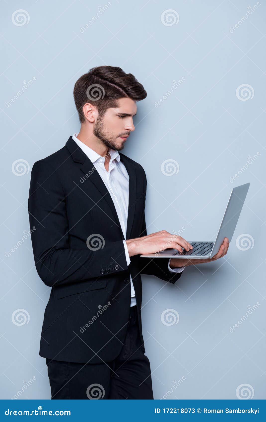 Young Handsome Man in Suit Holding Laptop and Typing Stock Image ...