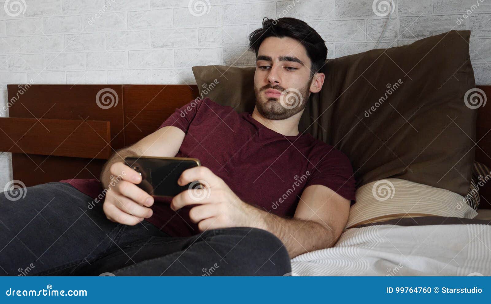 Young Man Watching Movie on Cellphone in Bed Stock Photo - Image of ...