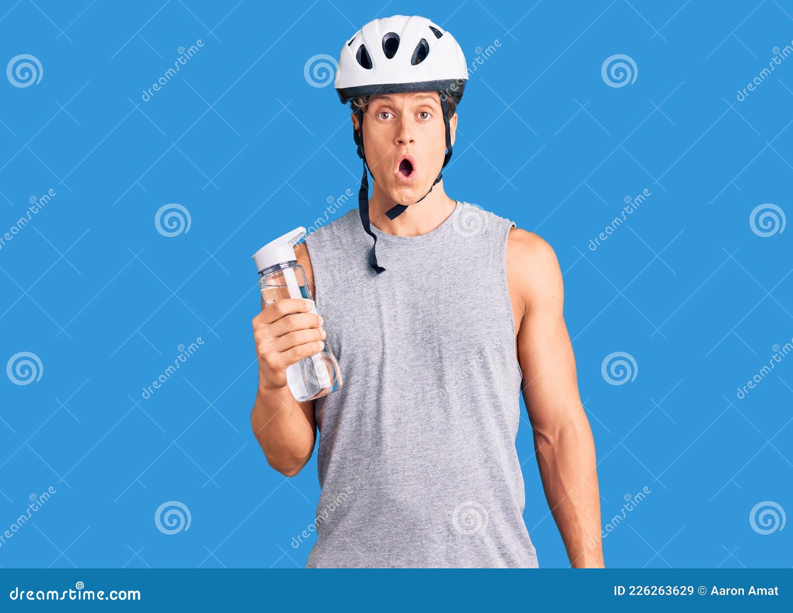 Young Handsome Man Wearing Bike Helmet Holding Bottle Of Water Scared