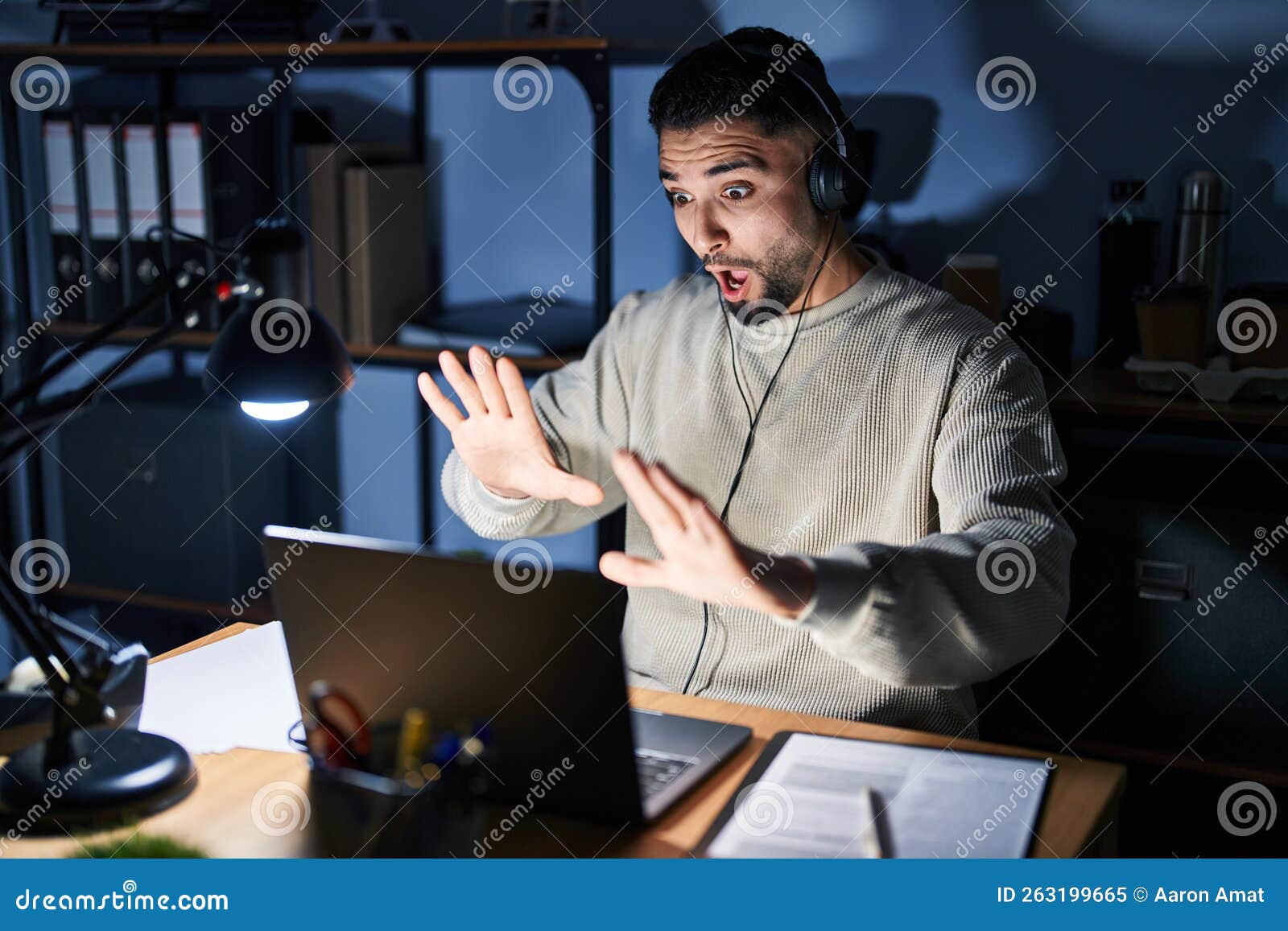 Young Handsome Man Working Using Computer Laptop at Night Afraid and ...