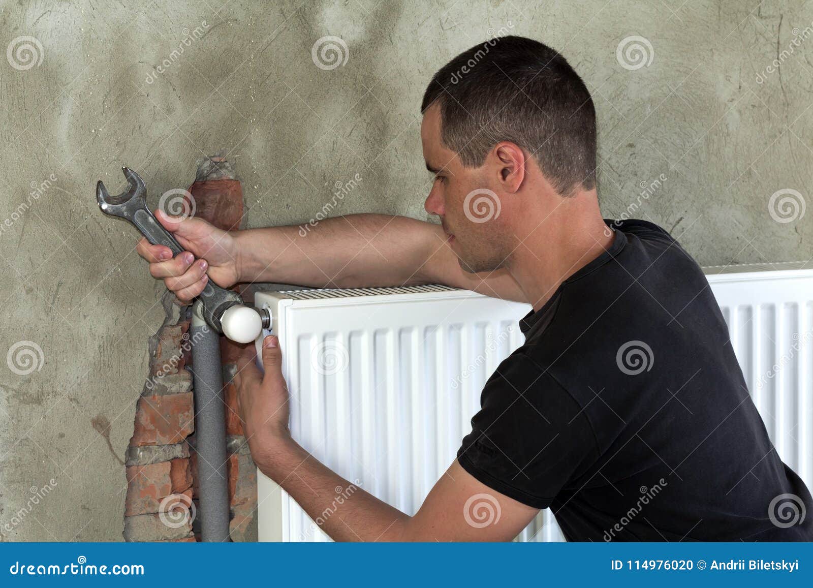 Young Handsome Professional Plumber Worker Installing Heating Radiator ...