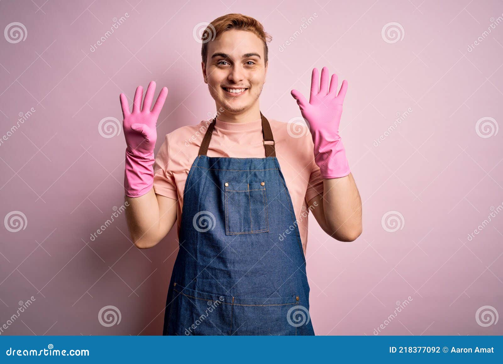 Young Handsome Redhead Cleaner Man Doing Housework Wearing Apron And Gloves Showing And Pointing