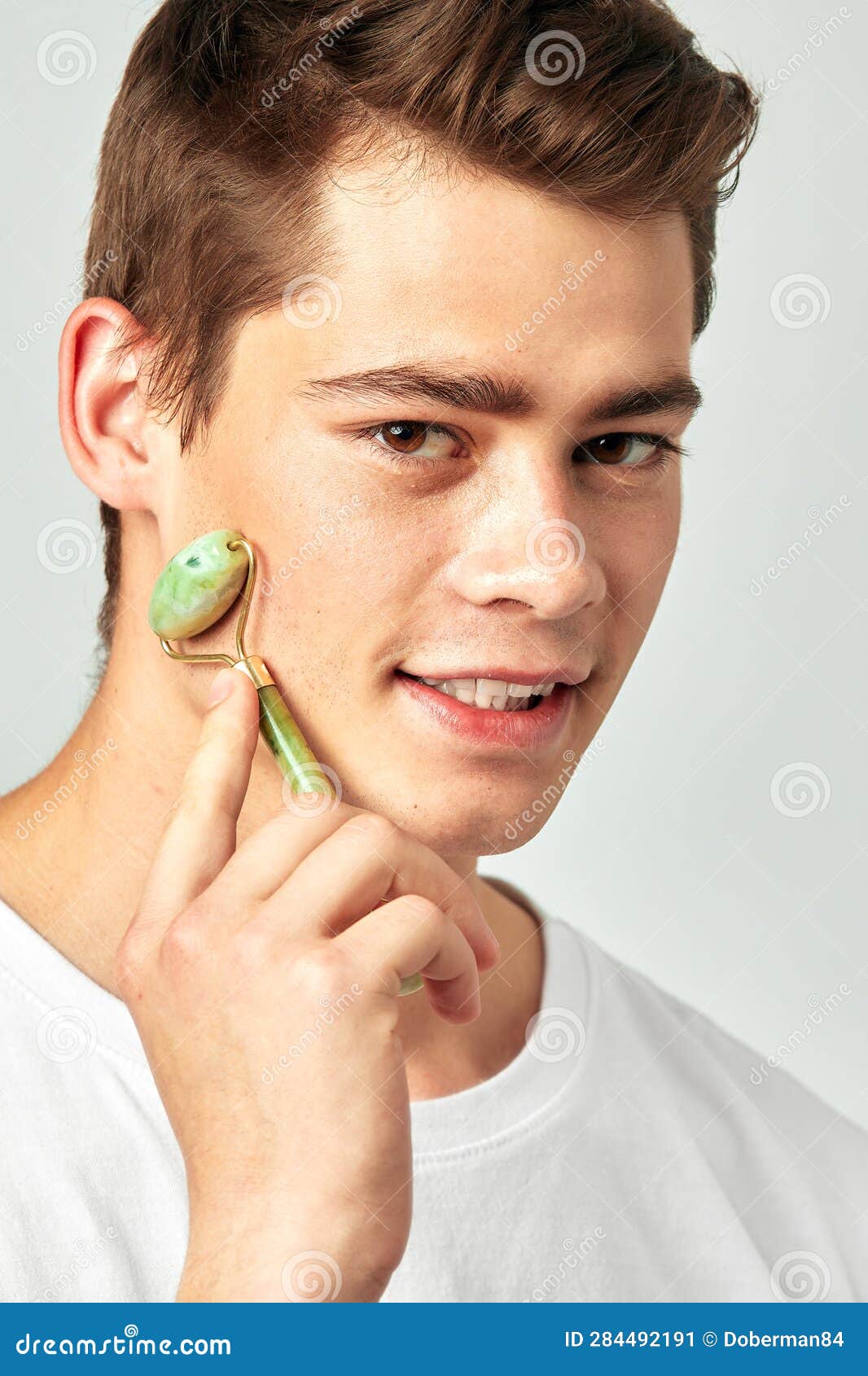 Young Handsome Smiling Brown Haired Guy Using Jade De-puffing Face ...