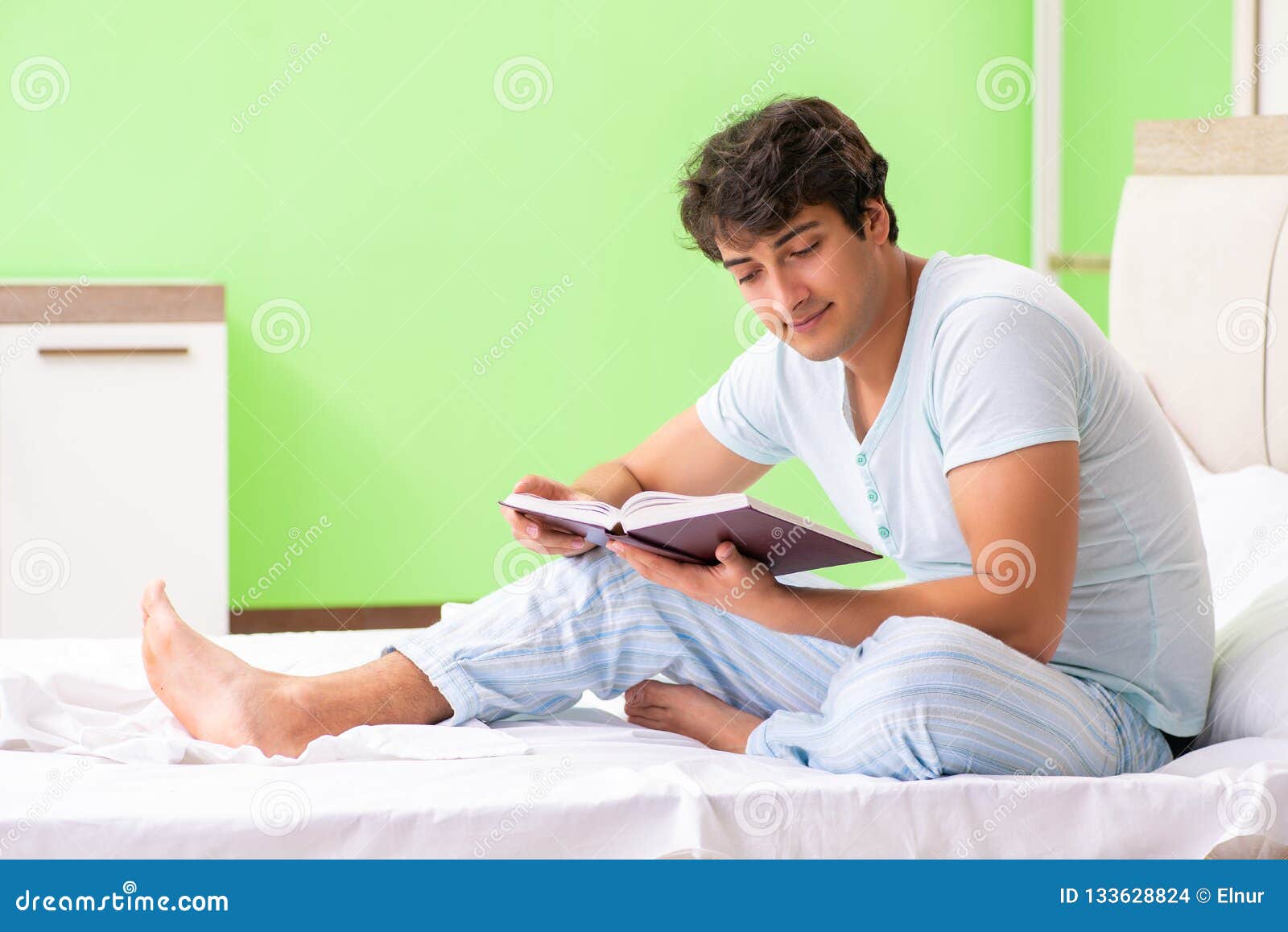 The Young Handsome Student Reading Book in the Bed Stock Photo - Image ...