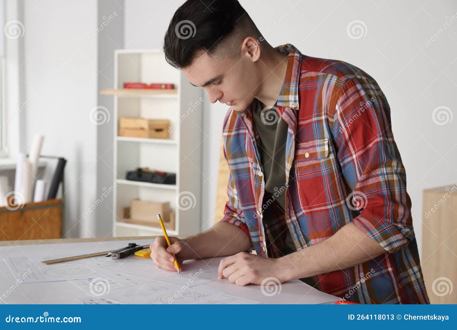 Young Handyman Working with Blueprints at Table in Room Stock Image ...