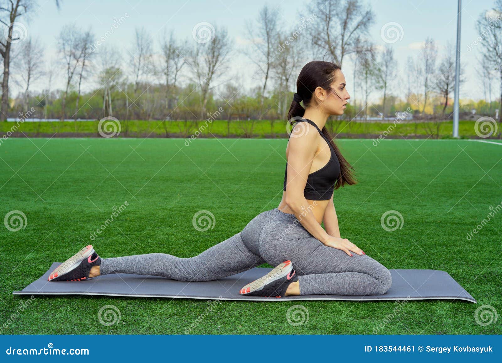 Young Happy And Beautiful Brunette Girl Doing Yoga Workout In Park