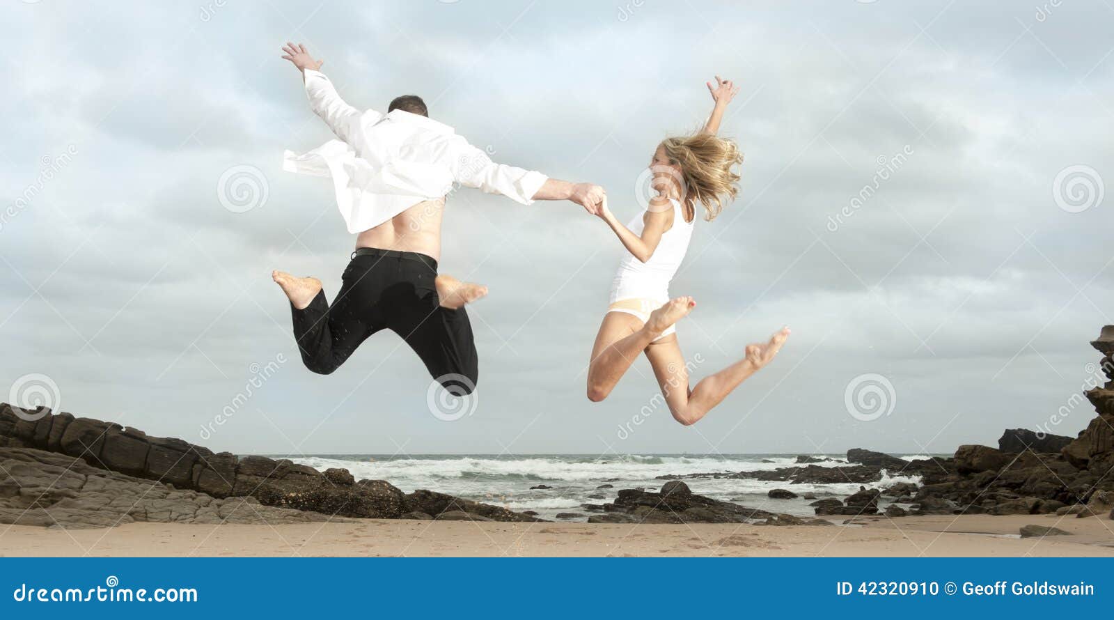 Young Happy Couple Jumping for Joy on Beach Stock Photo - Image of ...
