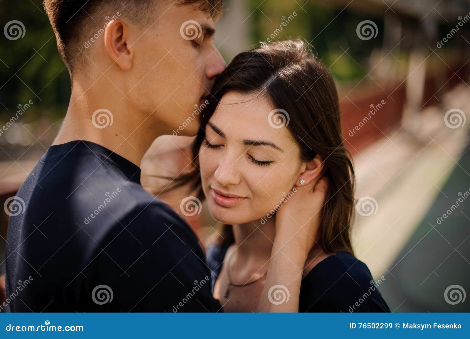 Young Happy Couple In Love In A Romantic Moment Of Man Kissing His Wife