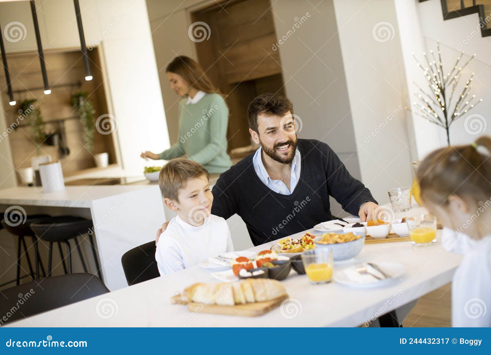 Young Happy Family Talking while Having Breakfast at Dining Table Stock ...