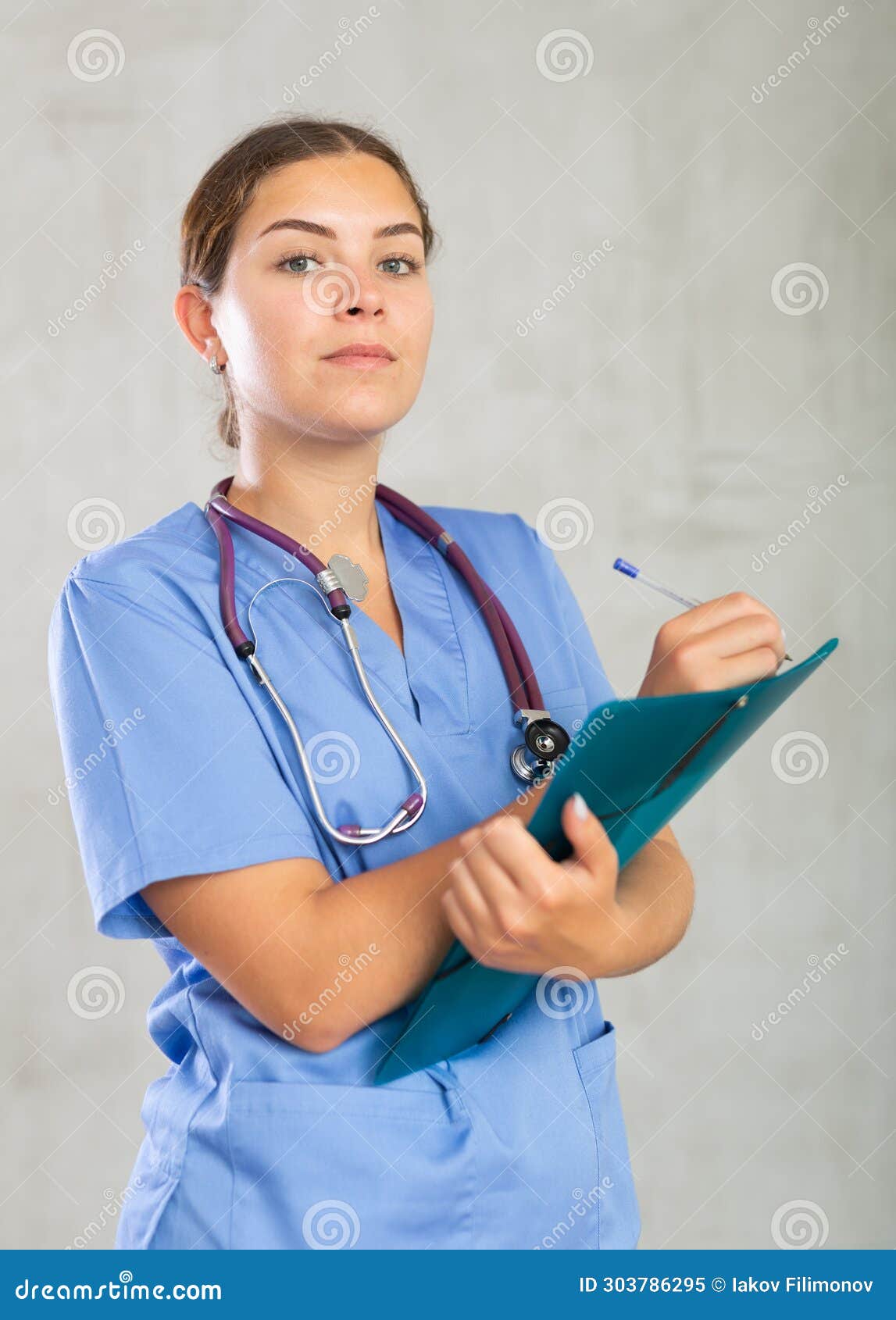 Young Happy Female Nurse Writing in File with Papers Stock Image ...