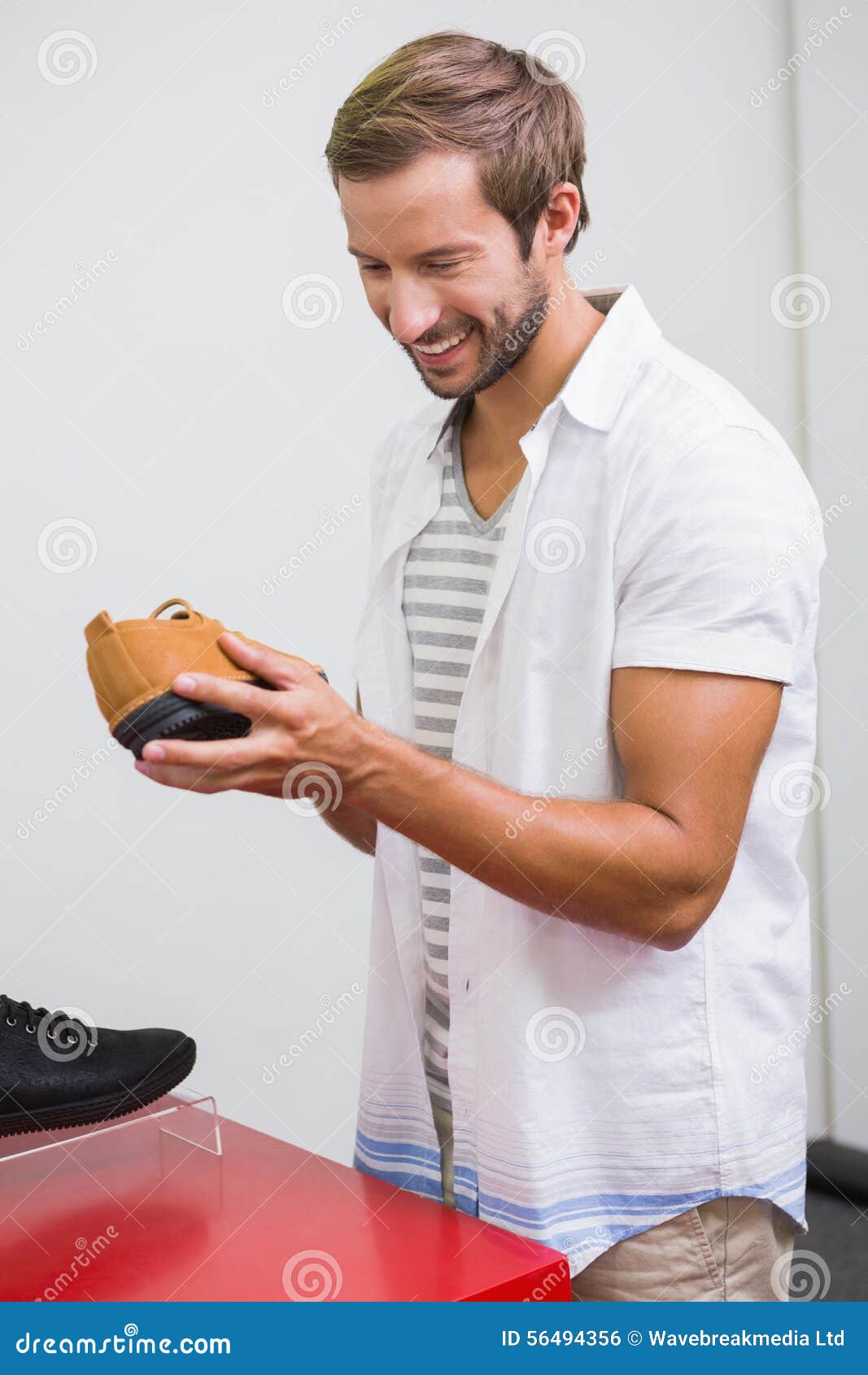 Young Happy Man Smiling and Looking at a Shoe Stock Photo - Image of ...
