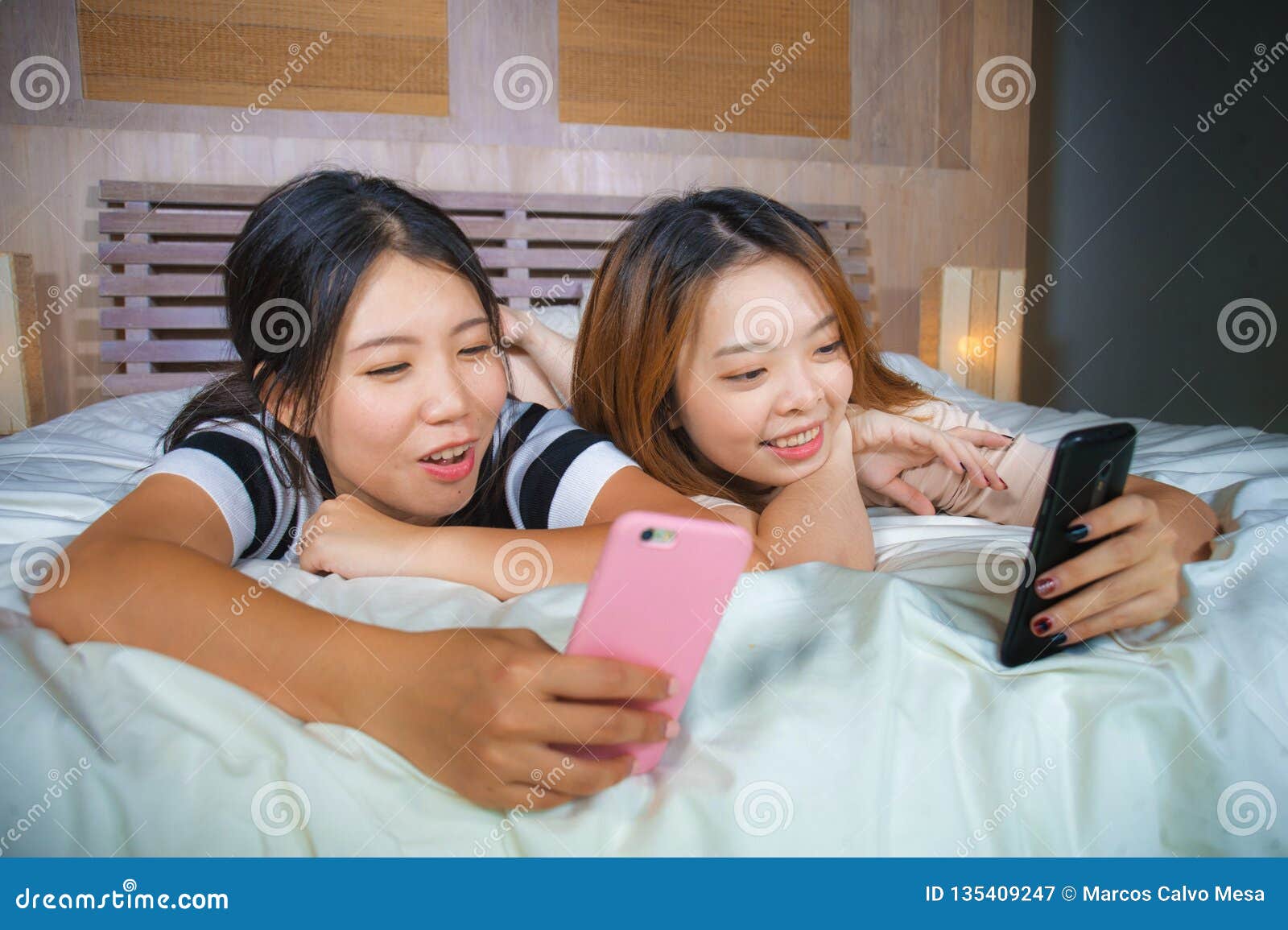 Young Happy And Pretty Asian Korean Girlfriends Sitting At Home Bedroom