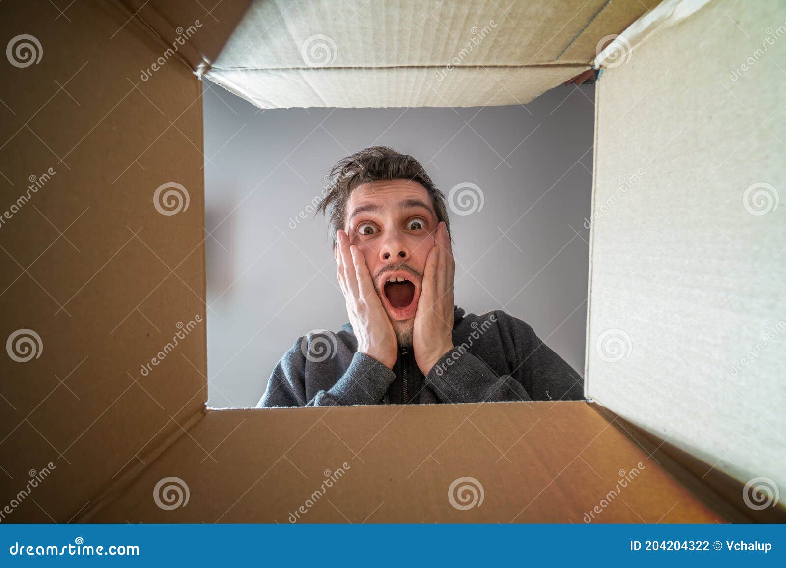 Young Happy Surprised Man is Opening Gift and Looking Inside Cardboard ...