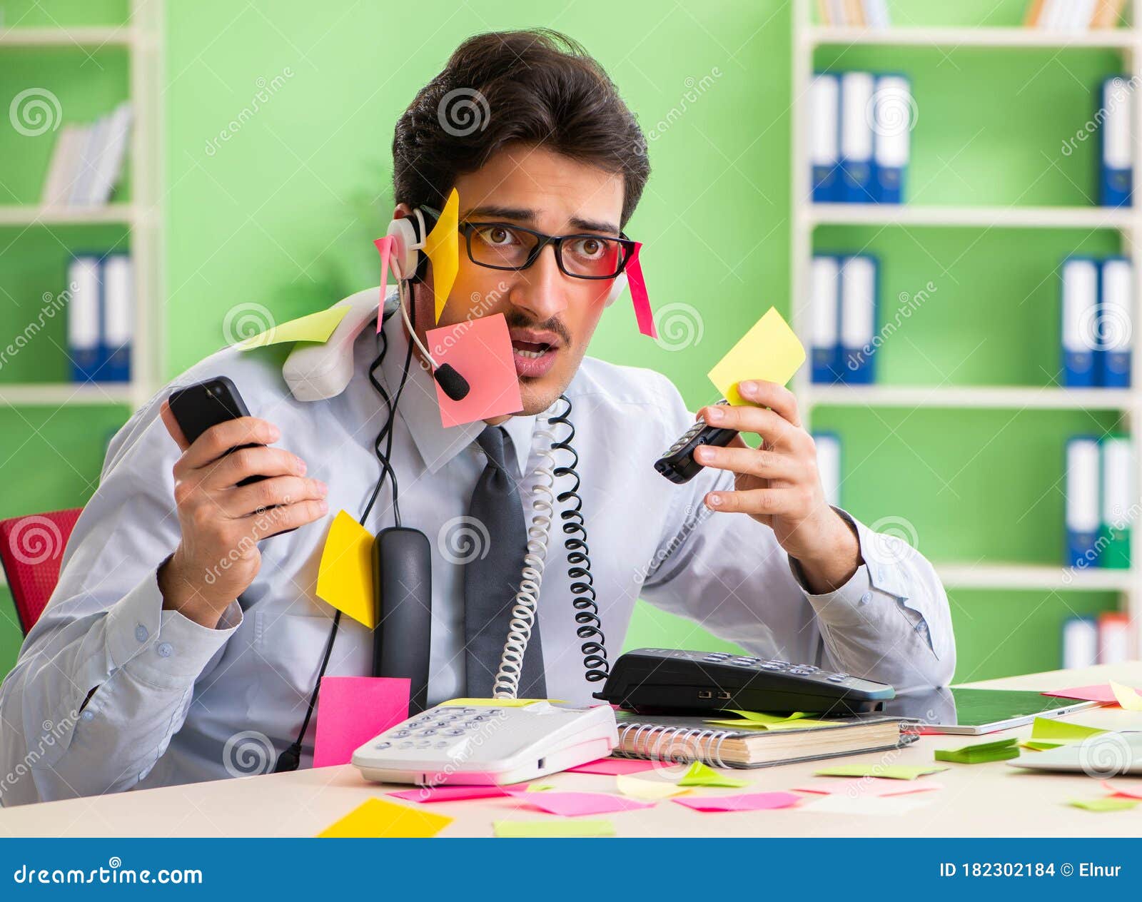 Young Help Desk Operator Working in Office with Many Conflicting Stock ...