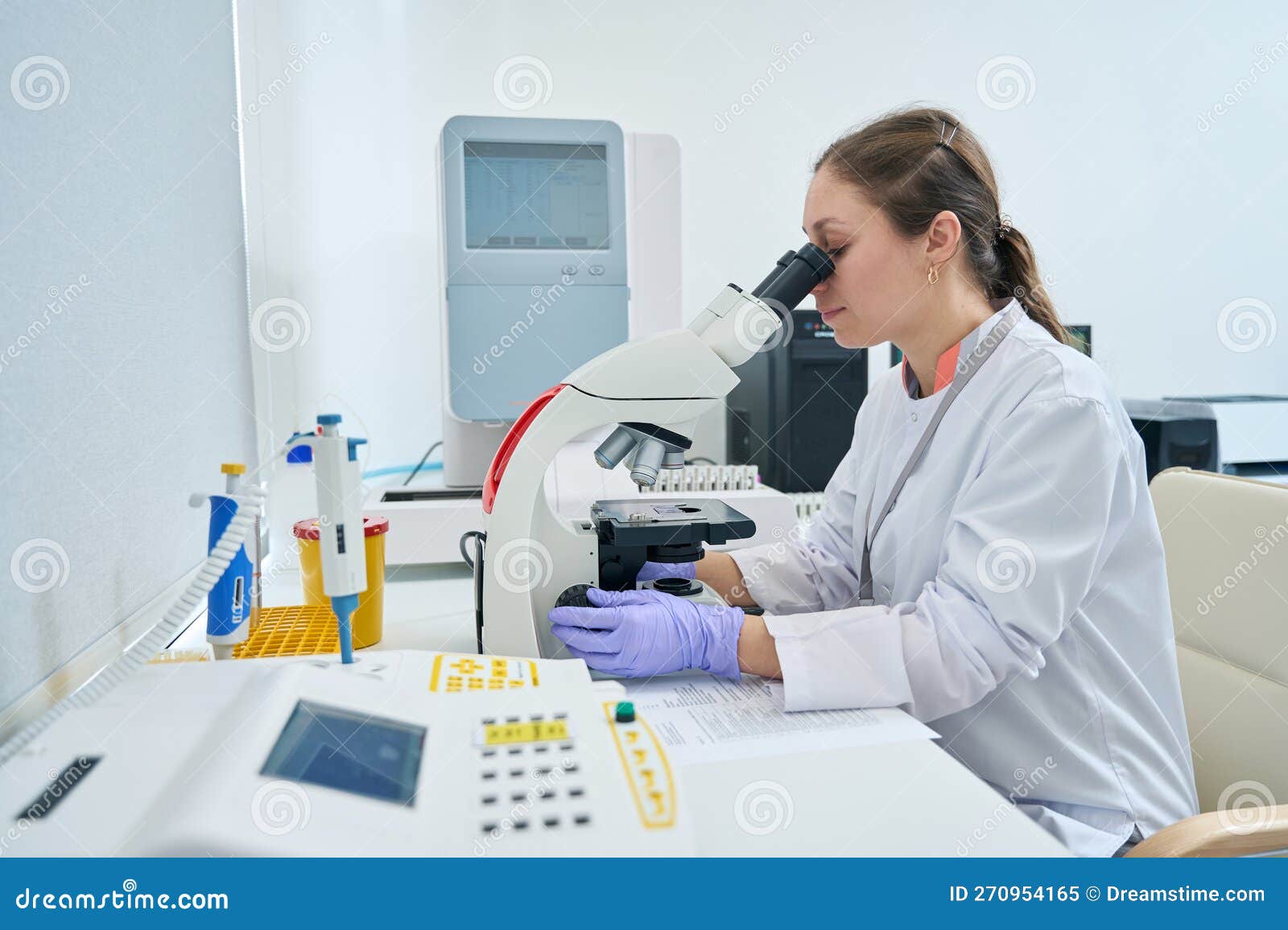 Young Hematologist Looks into the Eyepiece of a Microscope Stock Image ...