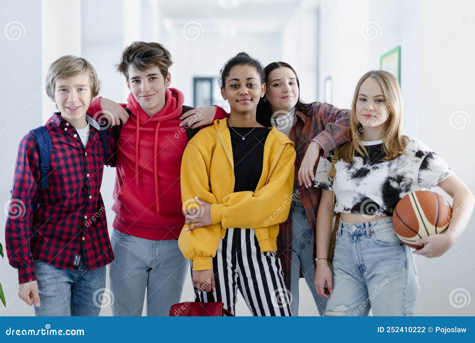 Young High School Students Walking in Corridor and Looking at Camera at ...